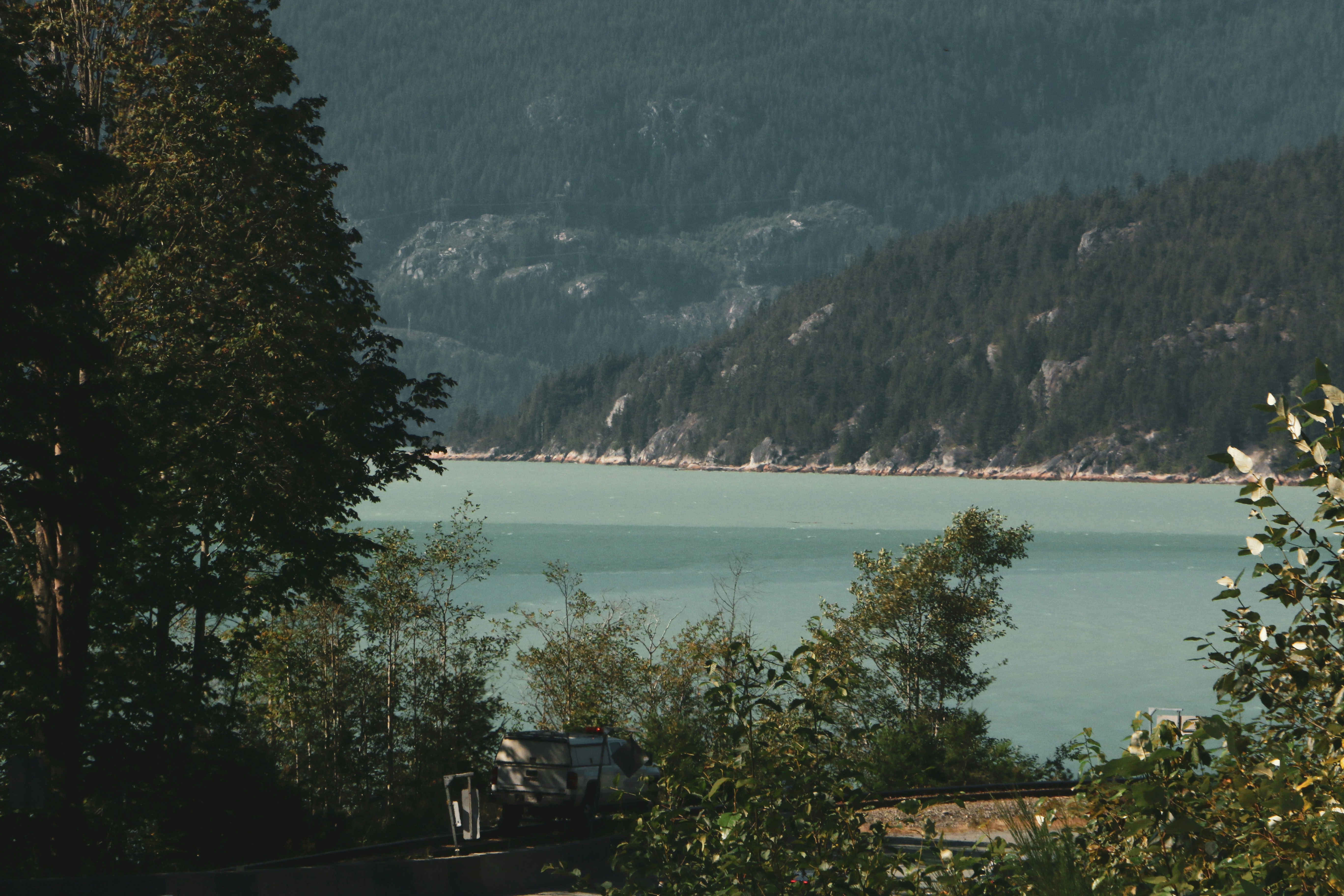 Turquoise Crest: Lake Between Pines and Distant Peaks