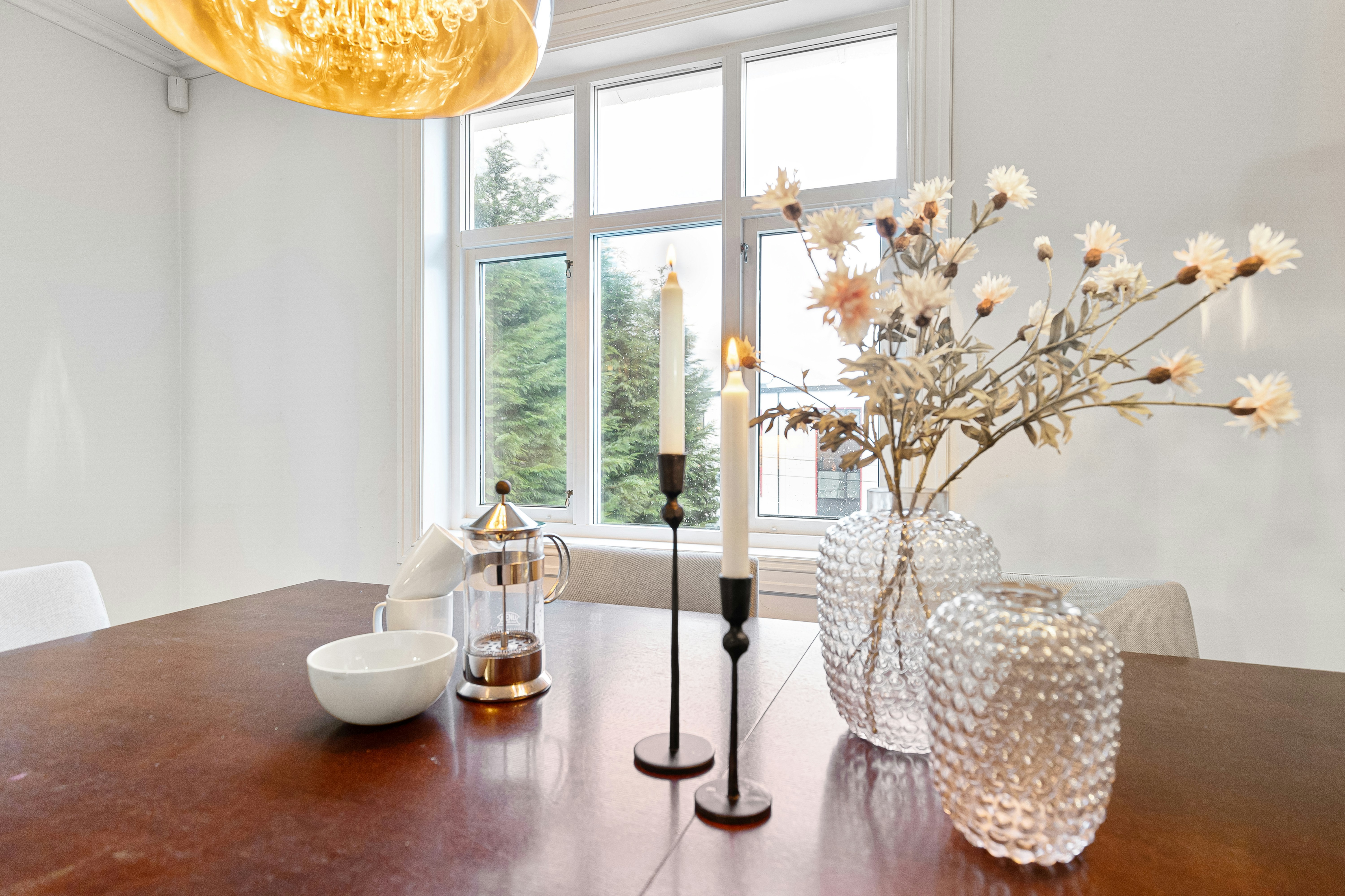 Minimalist Dining Table with Tall Candles and Frosted Glass Vases