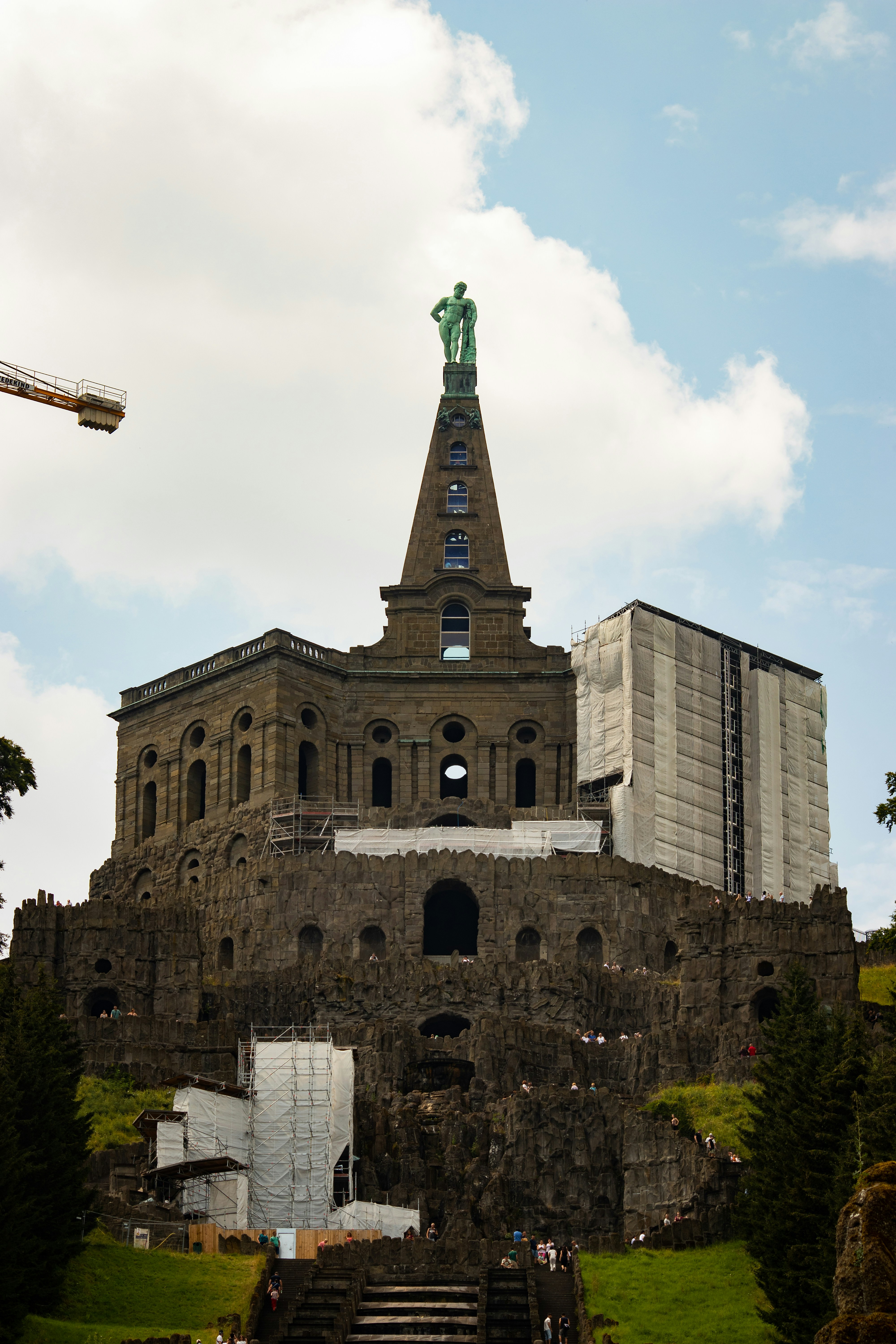 Sentinel on the Ridge: Green Statue Crowns a Weathered Fortress