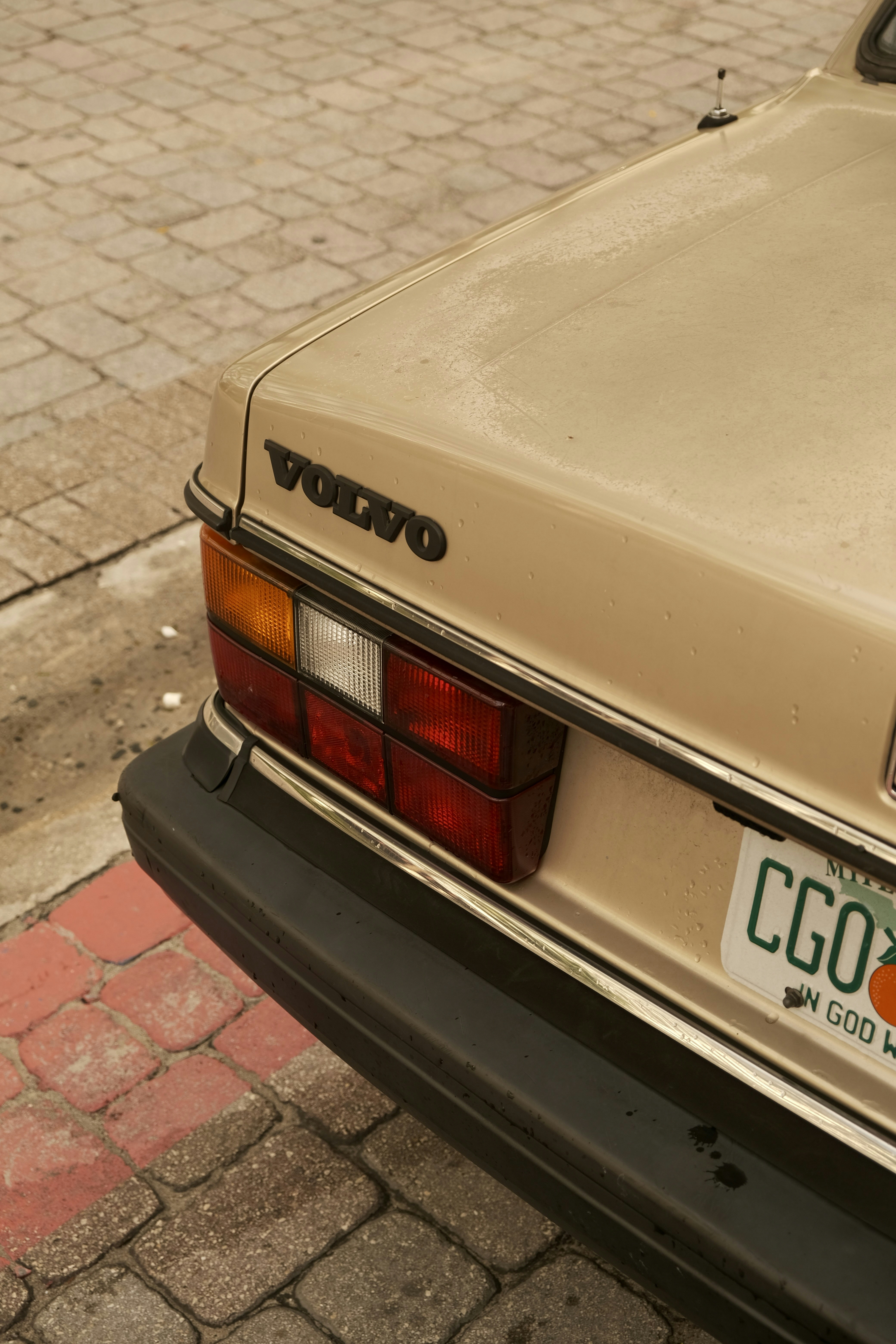 Beige Volvo Rear: The Brand Badge Anchored Between Taillight and Cobblestones