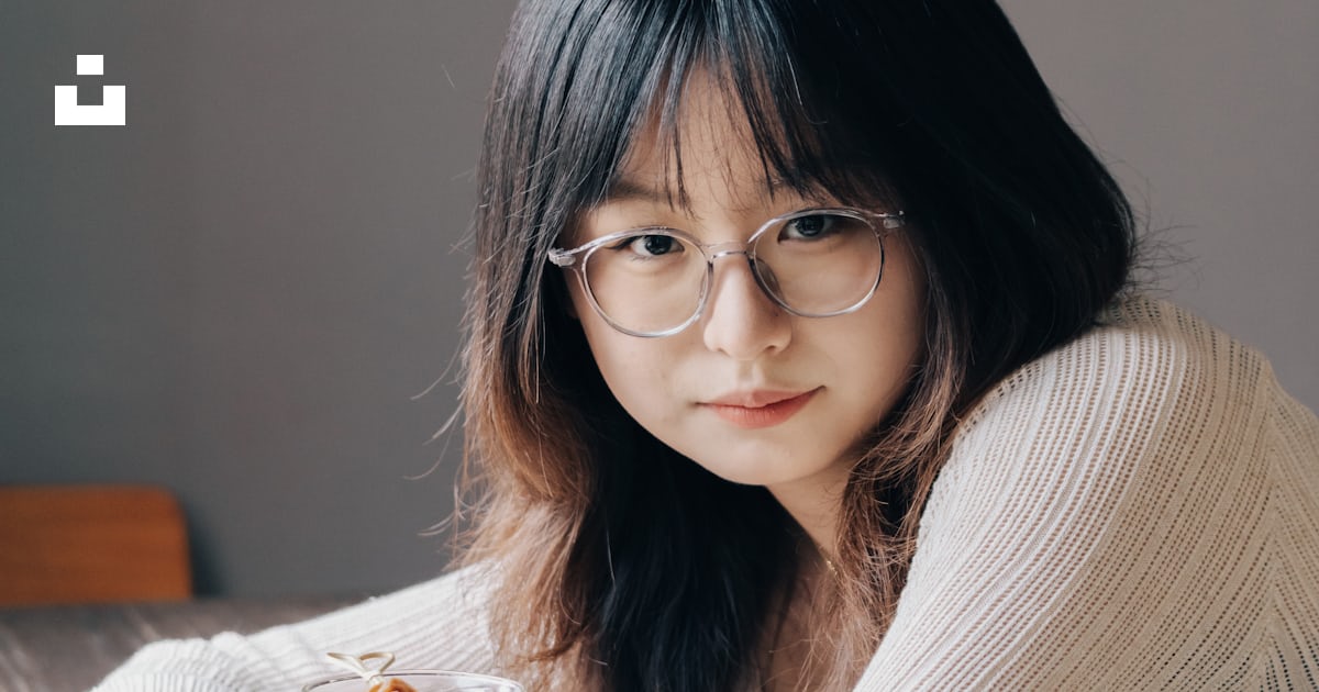 커피 한 잔을 들고 테이블에 앉아있는 여성 사진 Unsplash의 무료 성인 이미지