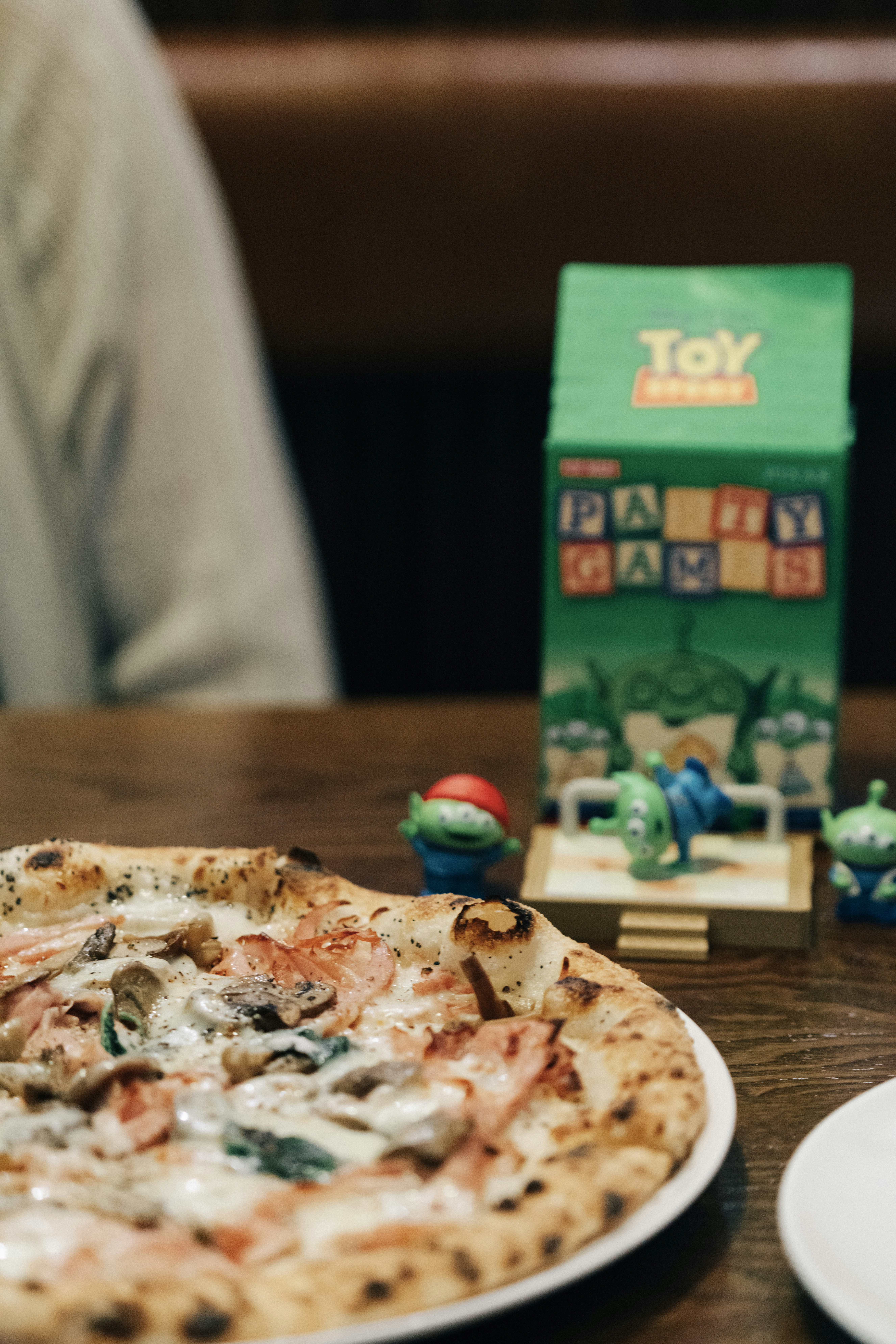 Green Toy Box and Pizza Scene at a Cozy Table