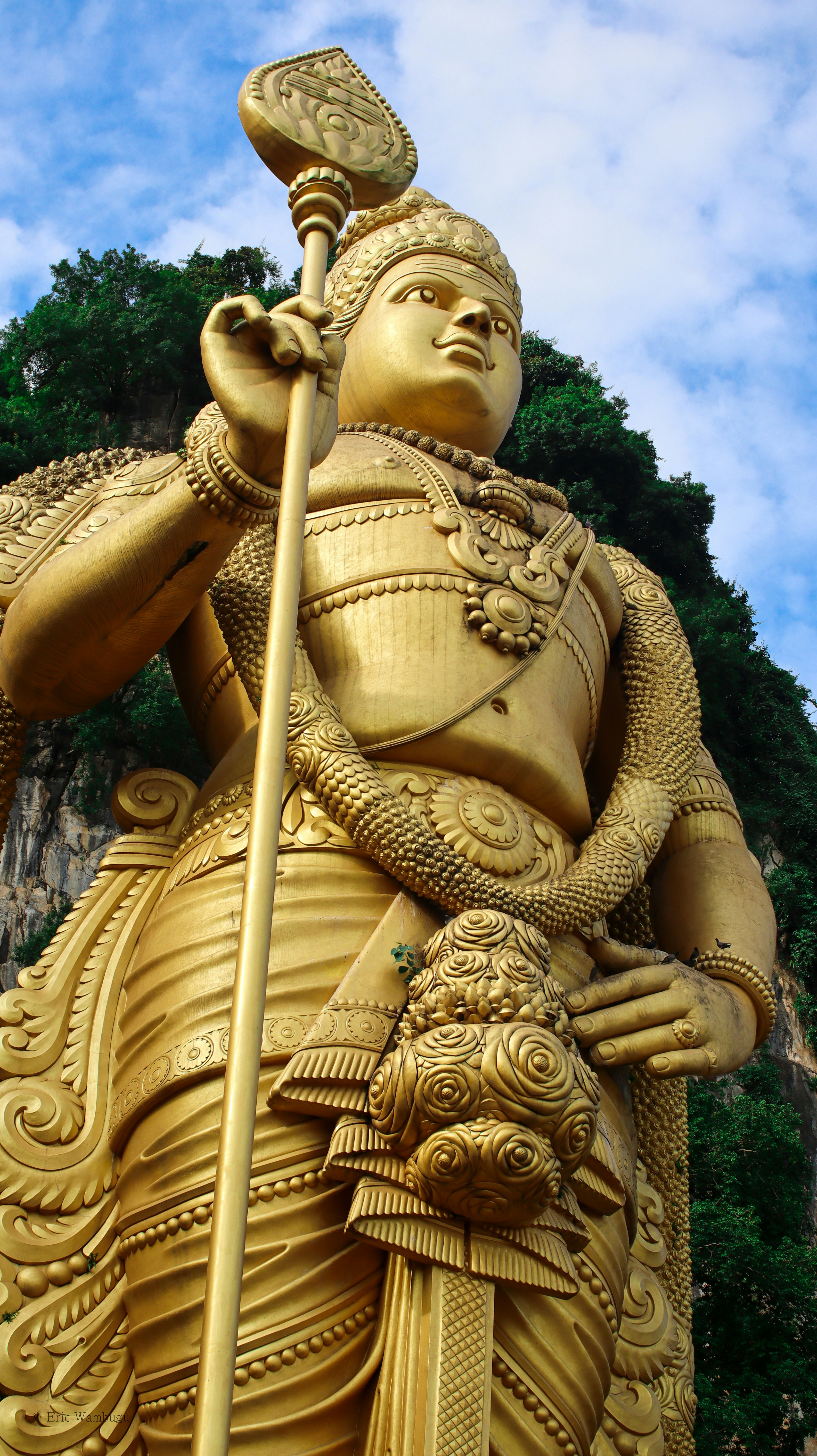 Gilded Sentinel: A colossal statue against a sapphire sky