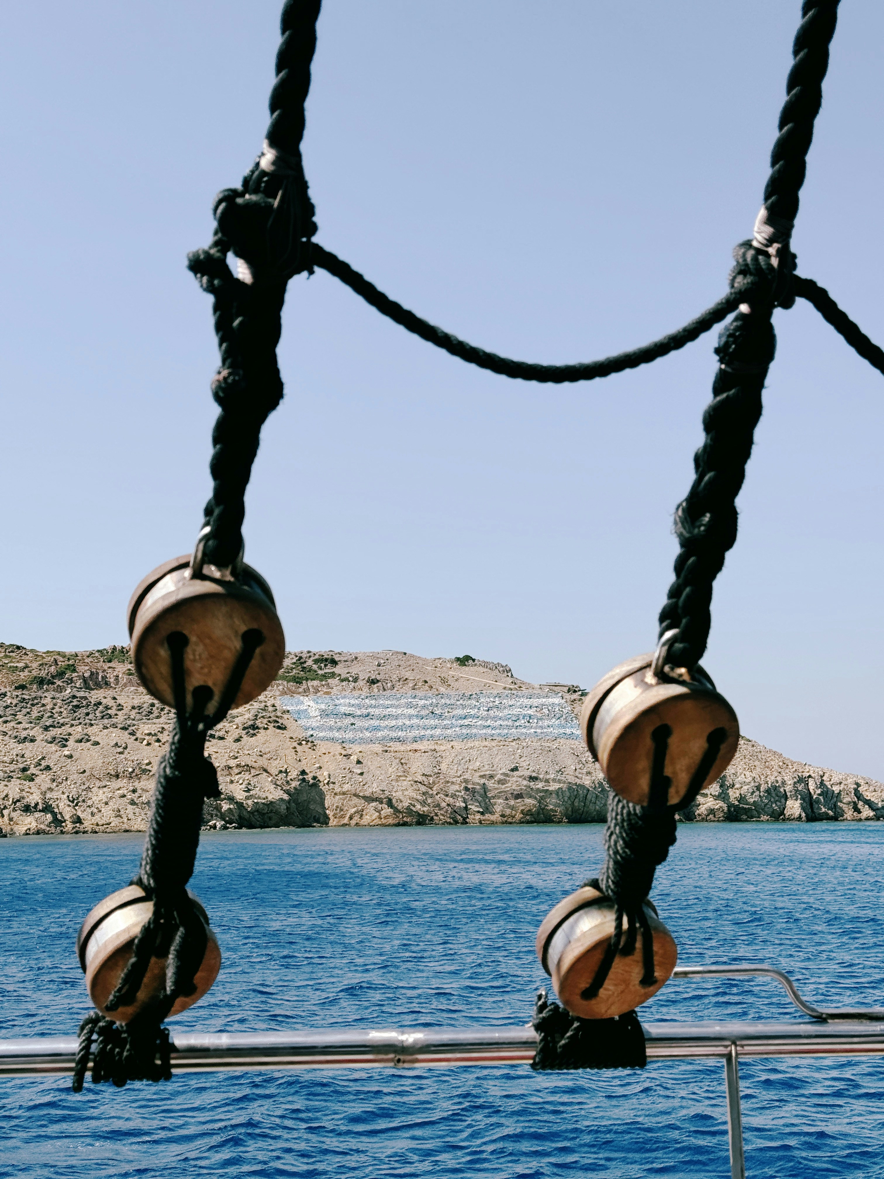 Rope Frame: Copper Floats and Knots Set Against a Sea Horizon