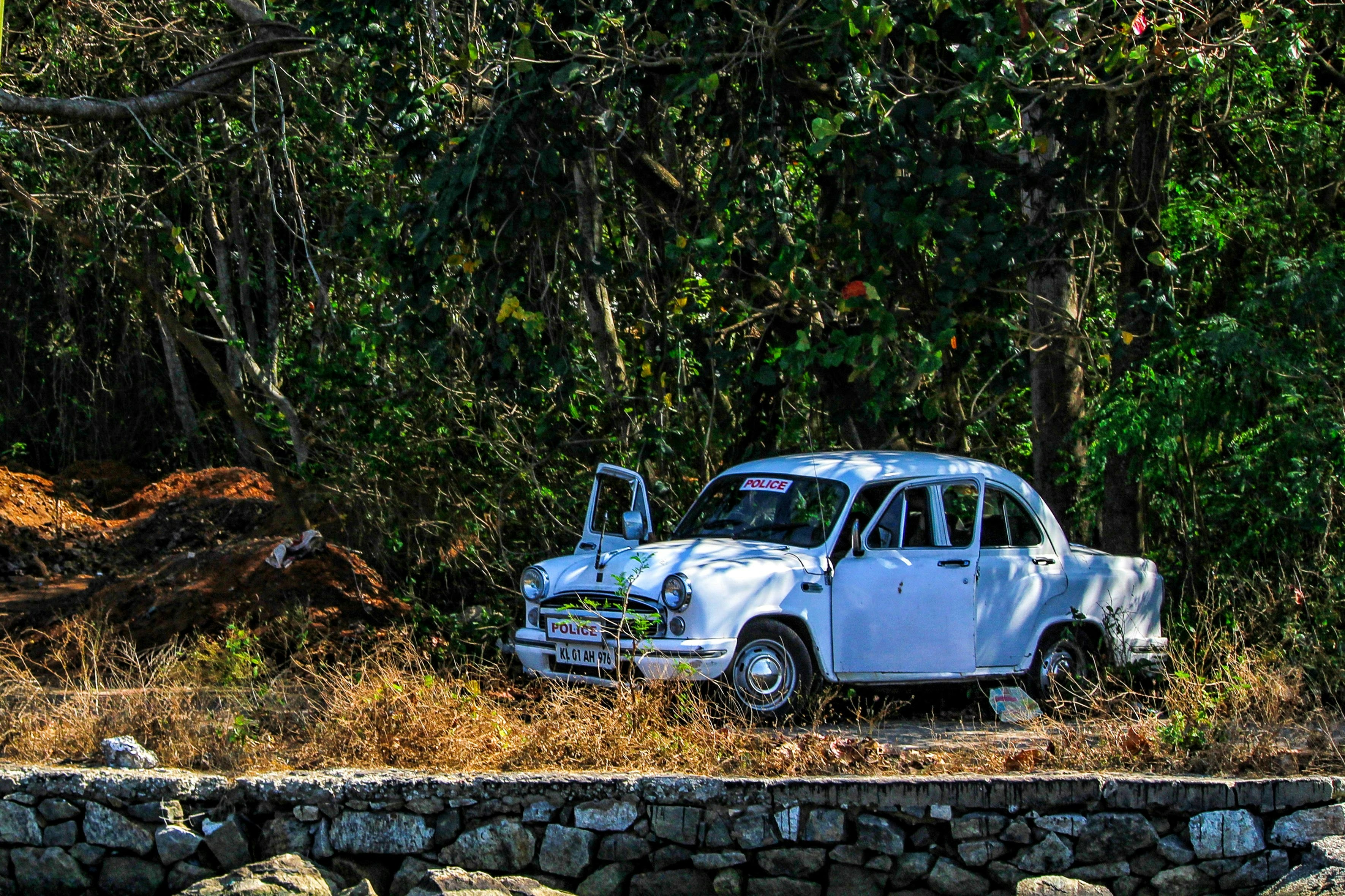 An old car is parked on the side of the road