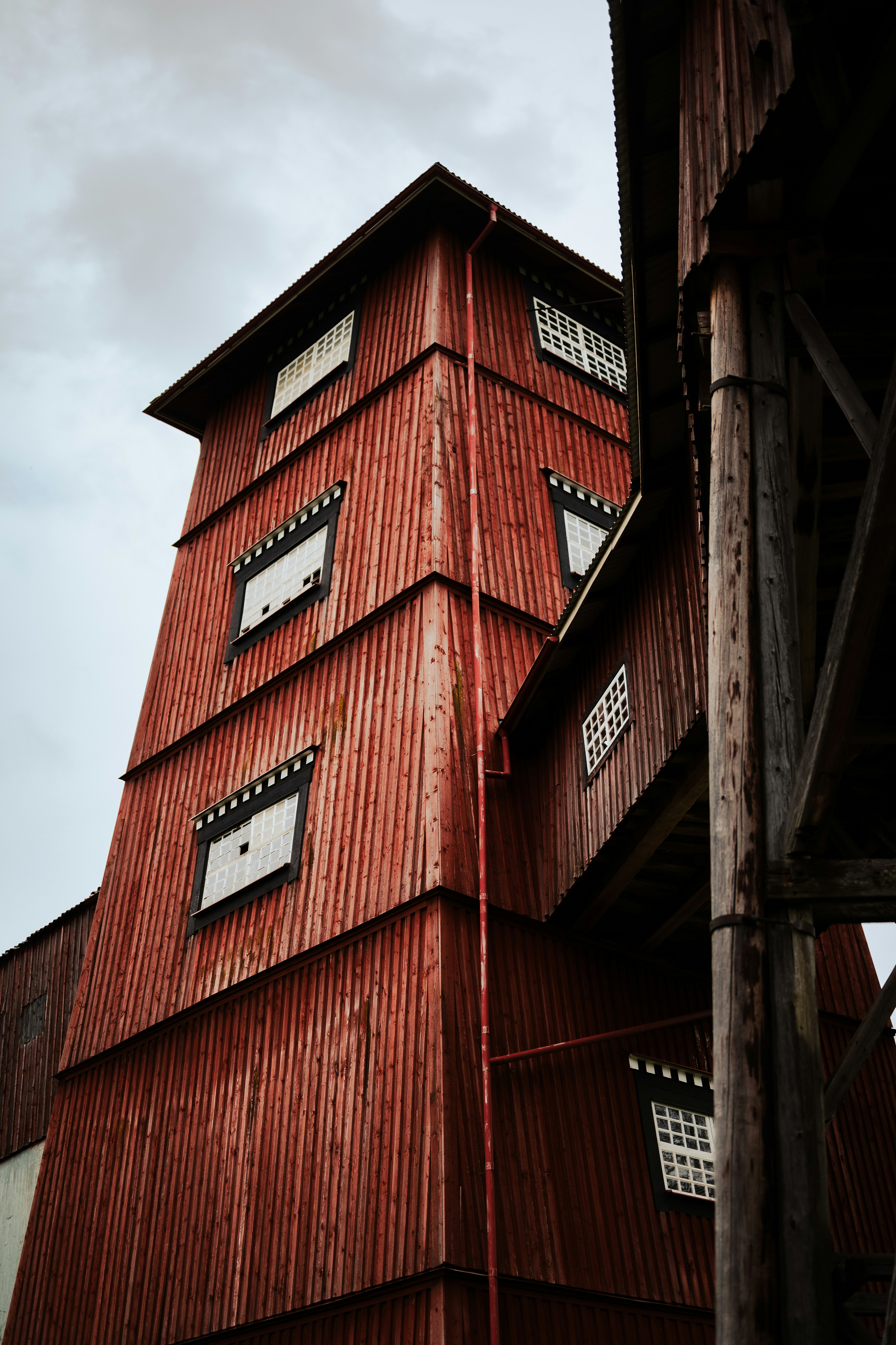 Crimson Timber Tower Rising Against a Cloudy Sky