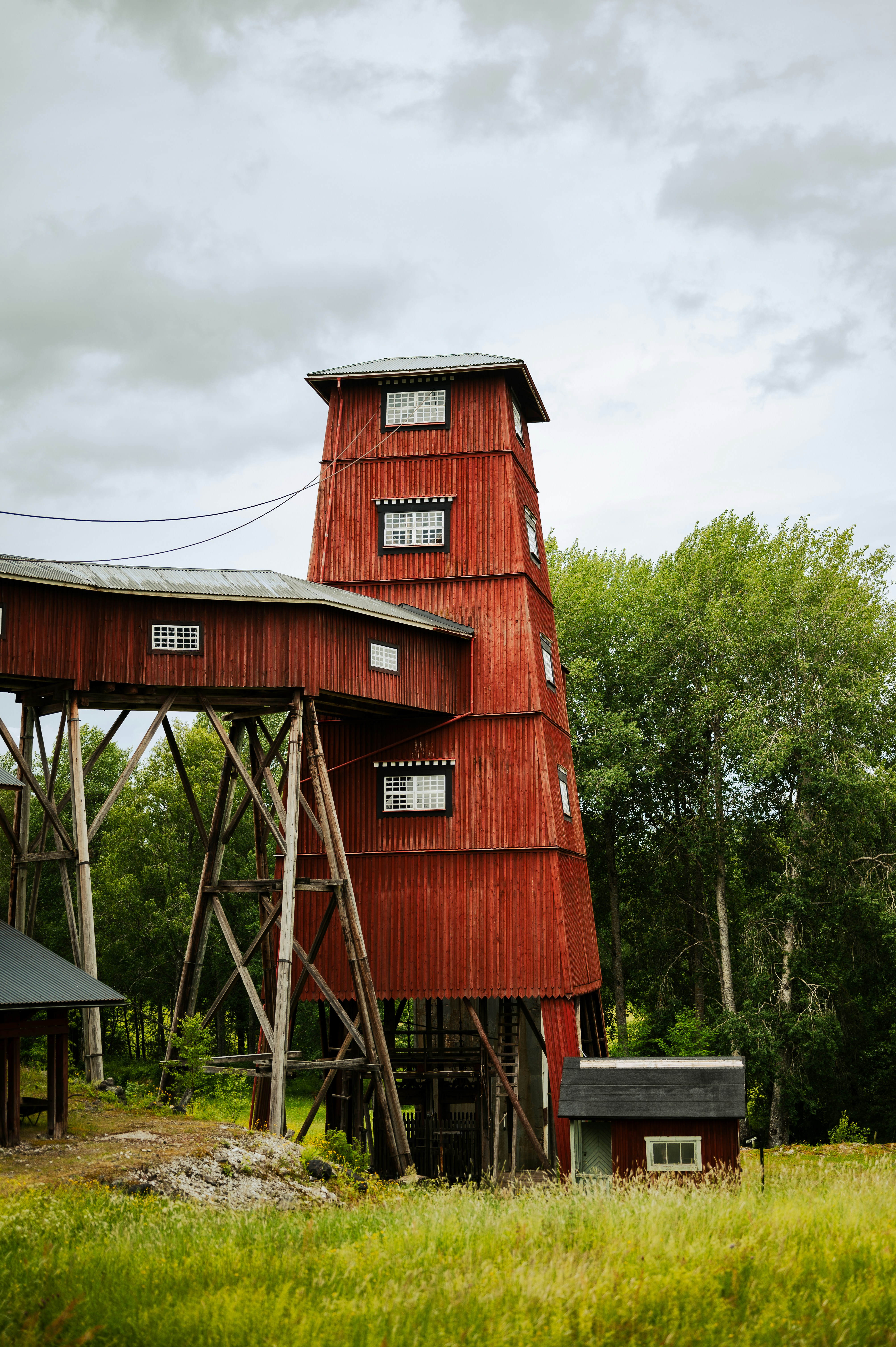 Red Timber Tower Rising from Green Banks