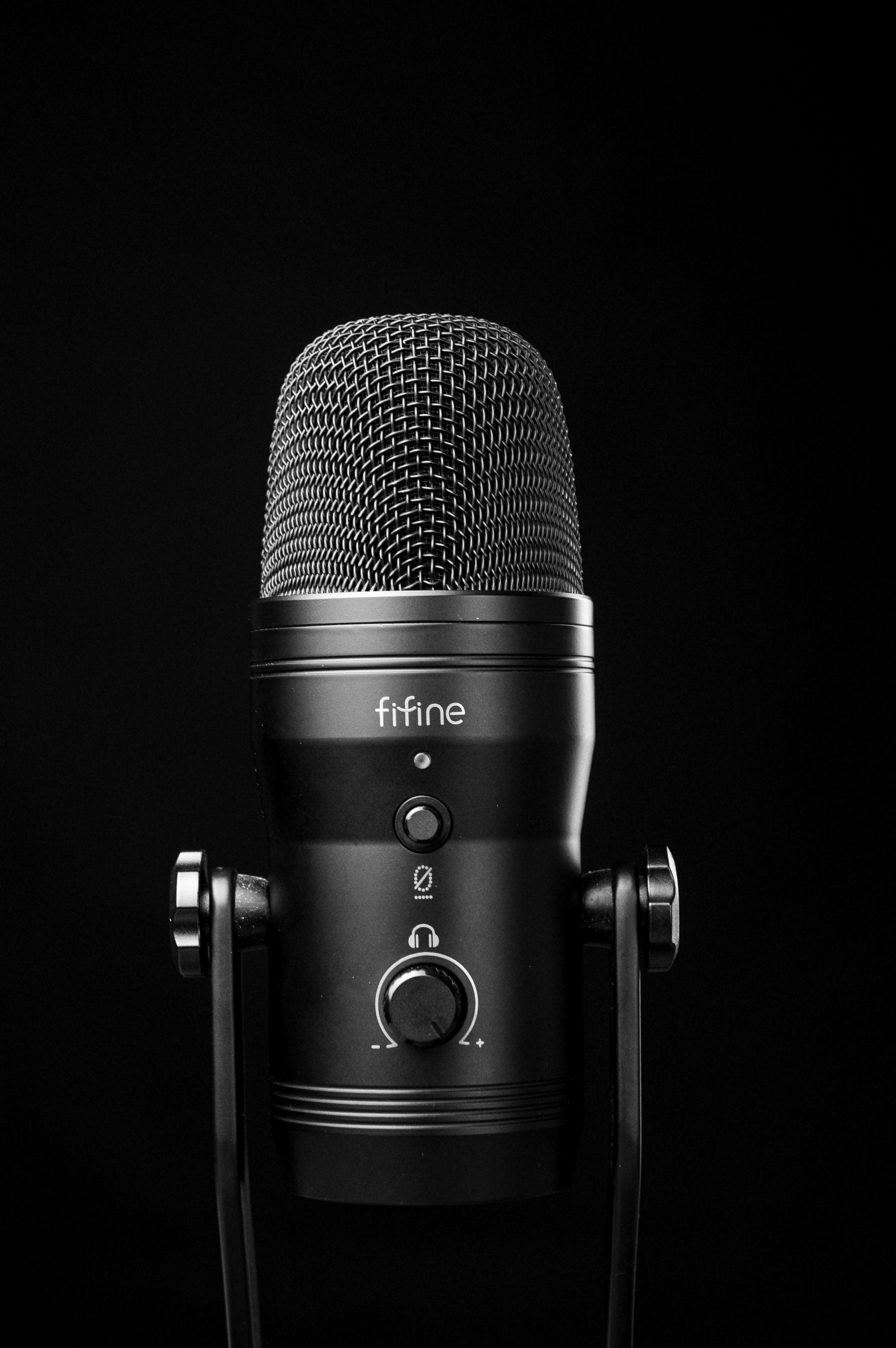 A black microphone on a stand against a black background photo – Free ...