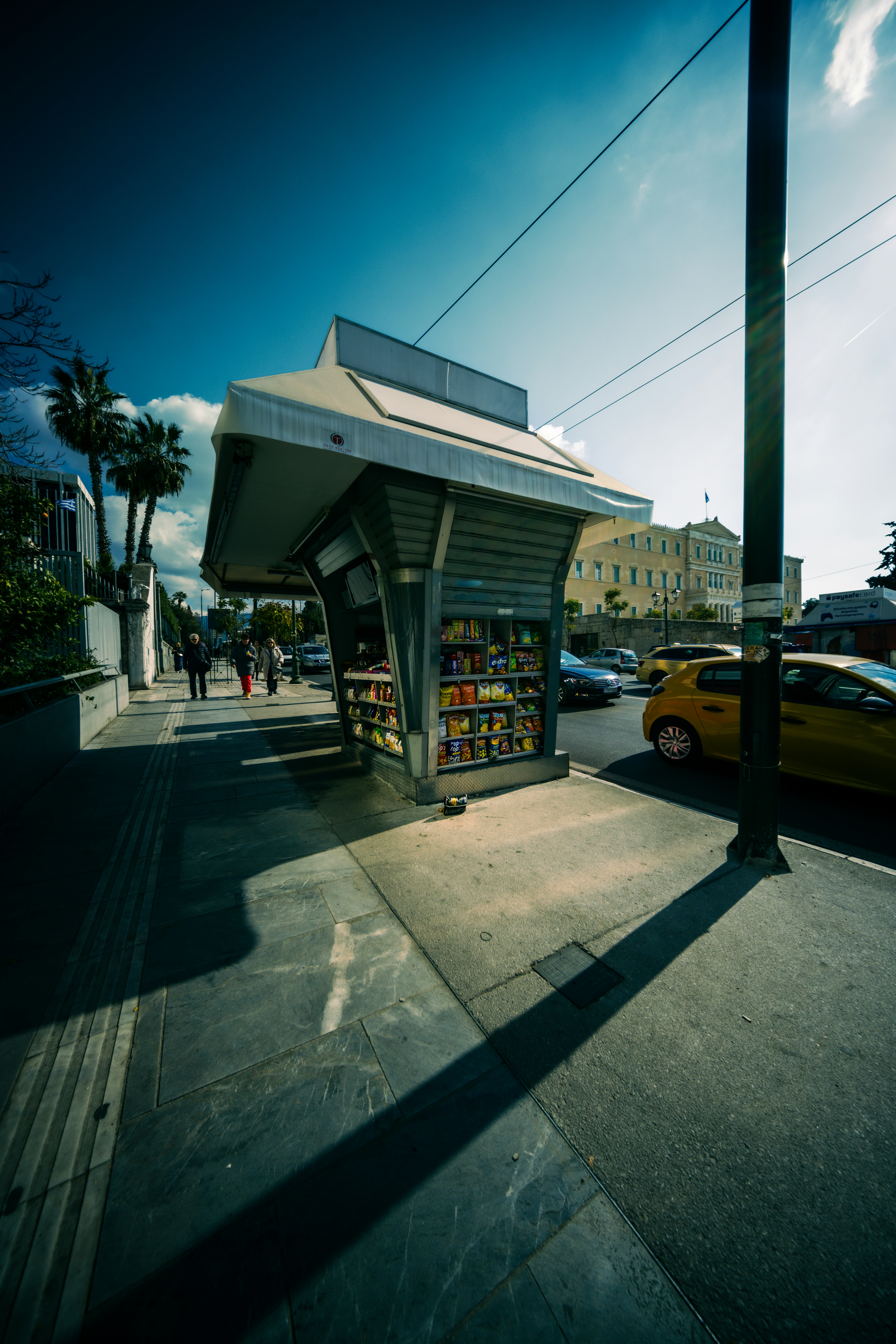Sunlit Newsstand at the Palm-Shadowed Boulevard