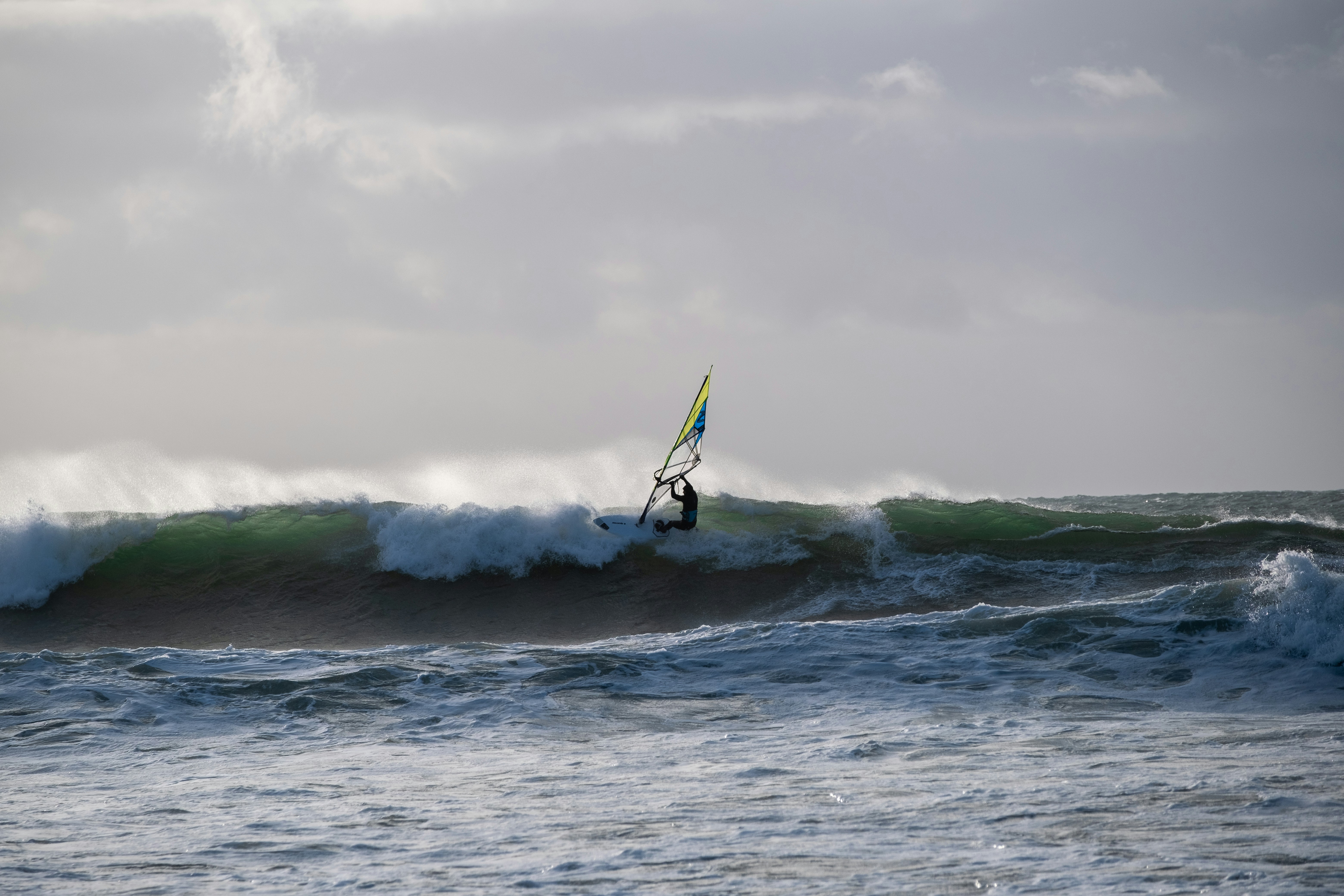 A person riding a surfboard on a wave in the ocean photo – Free ...