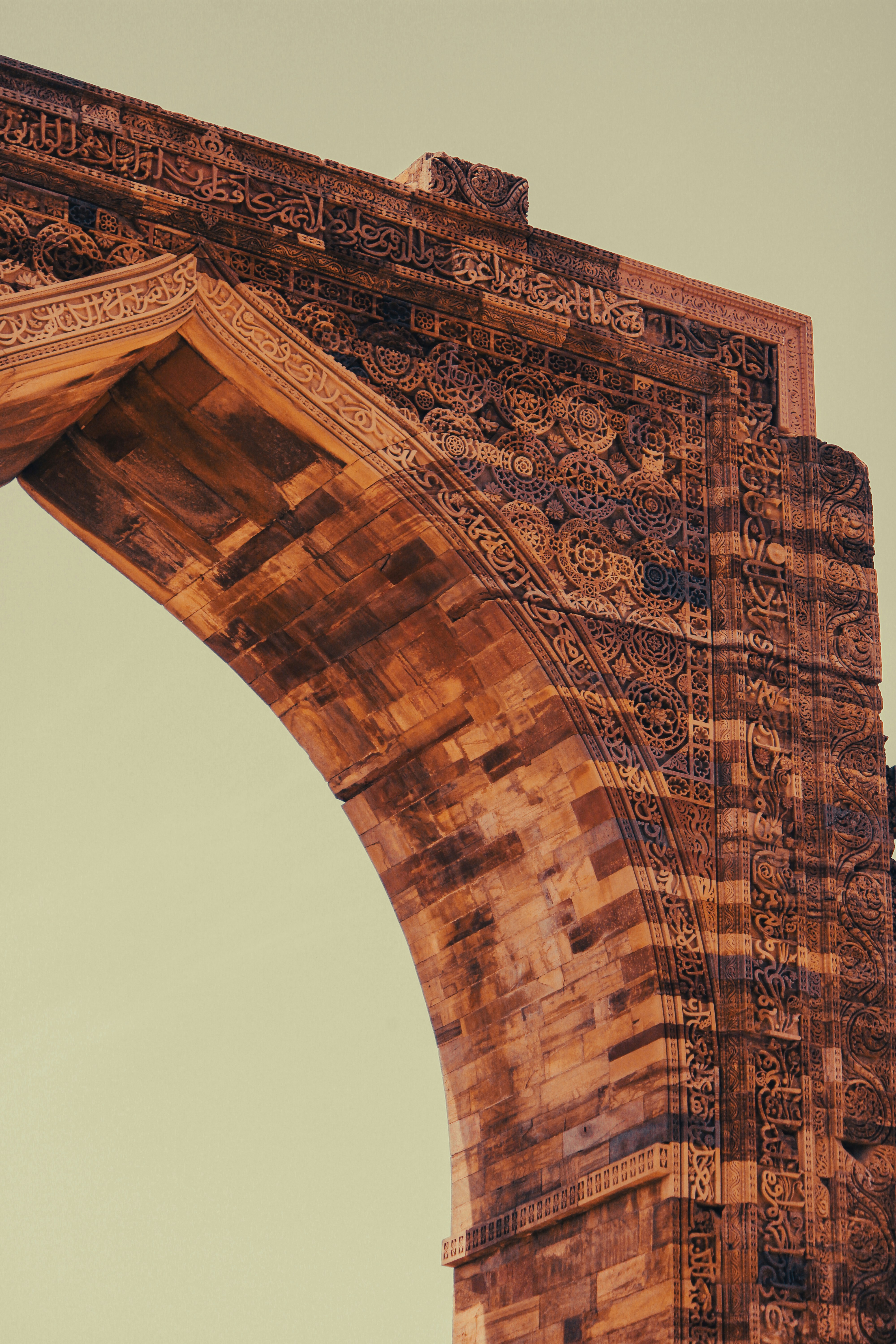 Sunlit Carved Arch: A Close-Up Portrait of Time-Worn Stone