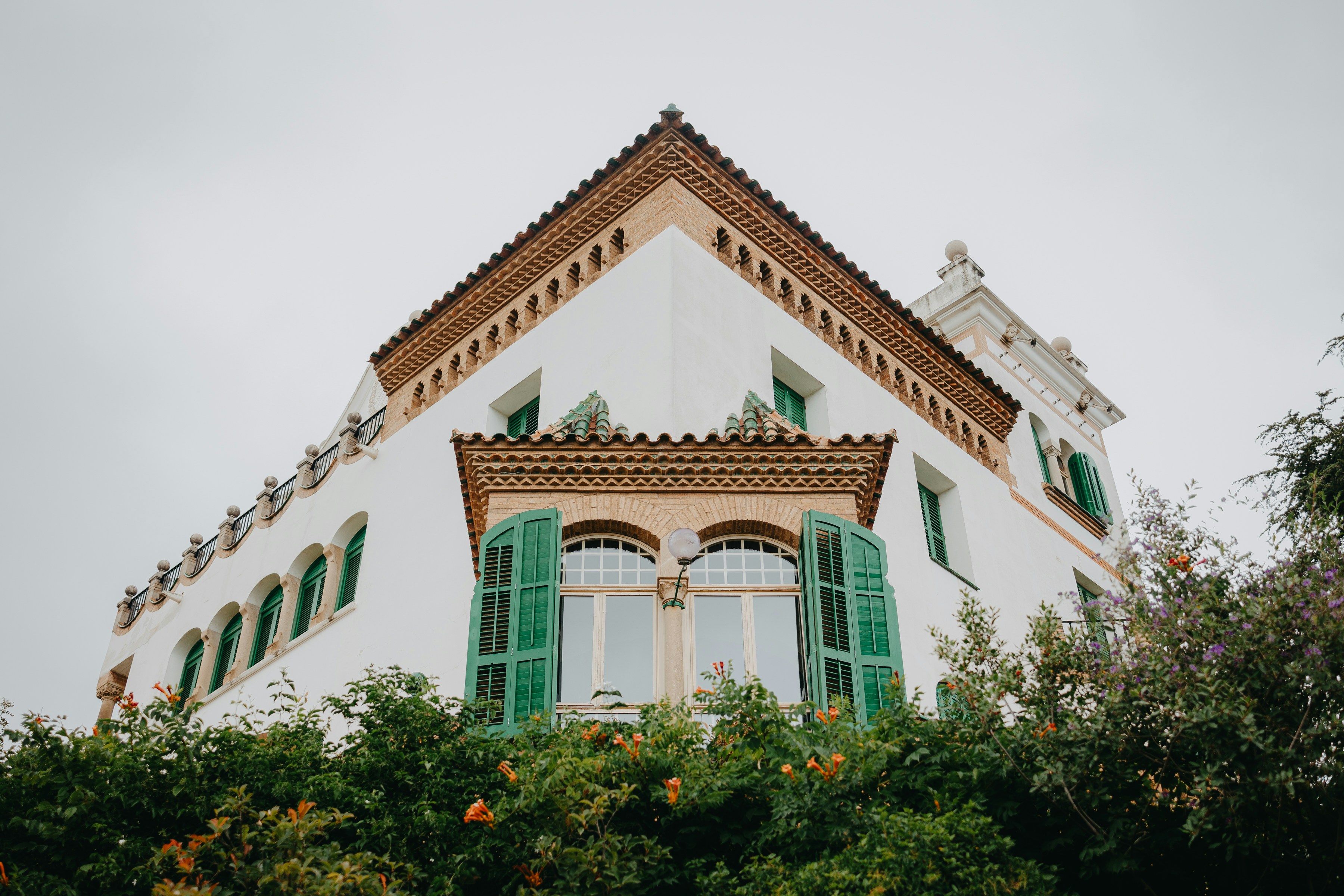 Un gran edificio blanco con persianas verdes en la parte superior foto ...