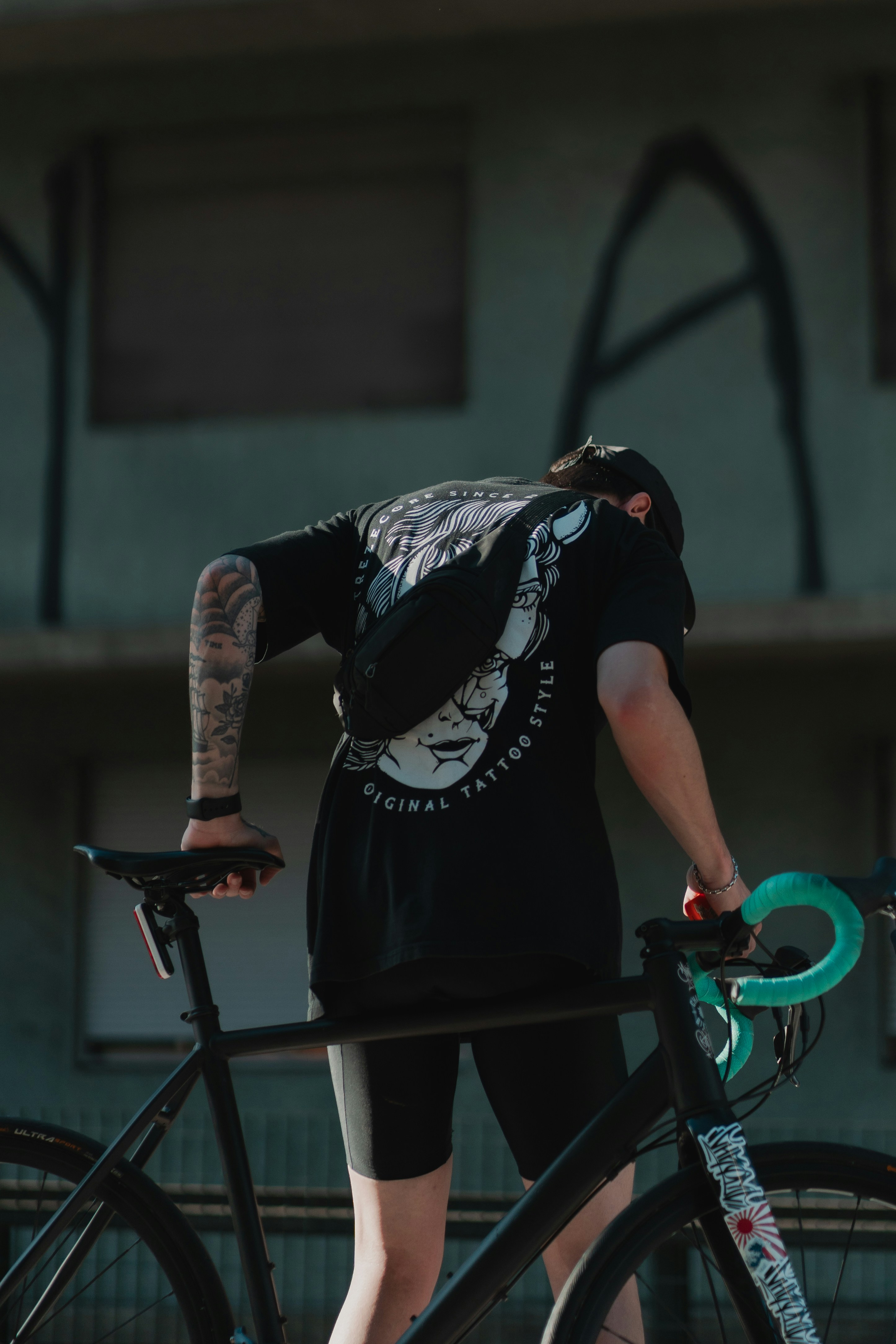 A man standing next to a bike in front of a building