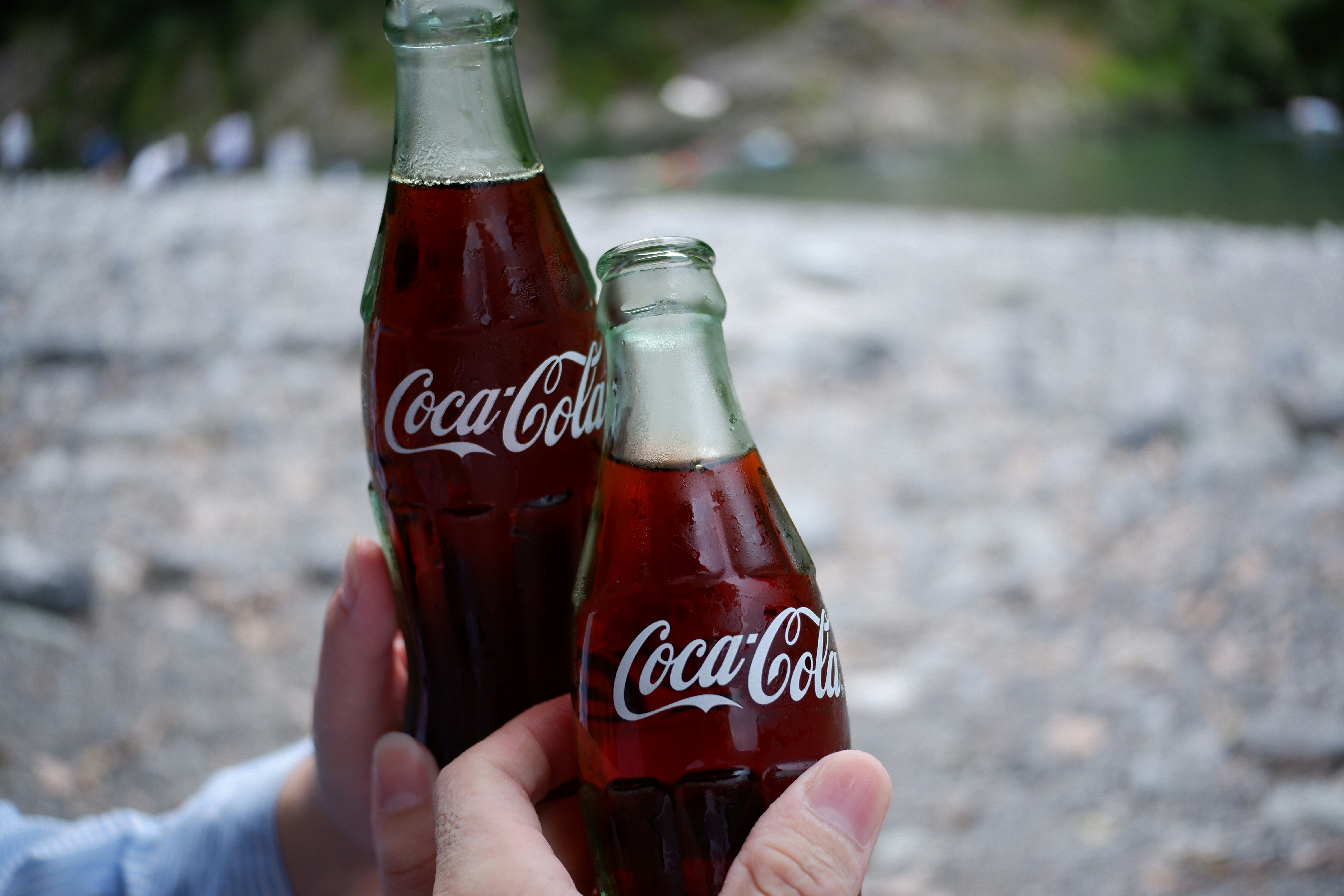Una persona sosteniendo dos botellas de coca cola foto – Imagen de ...