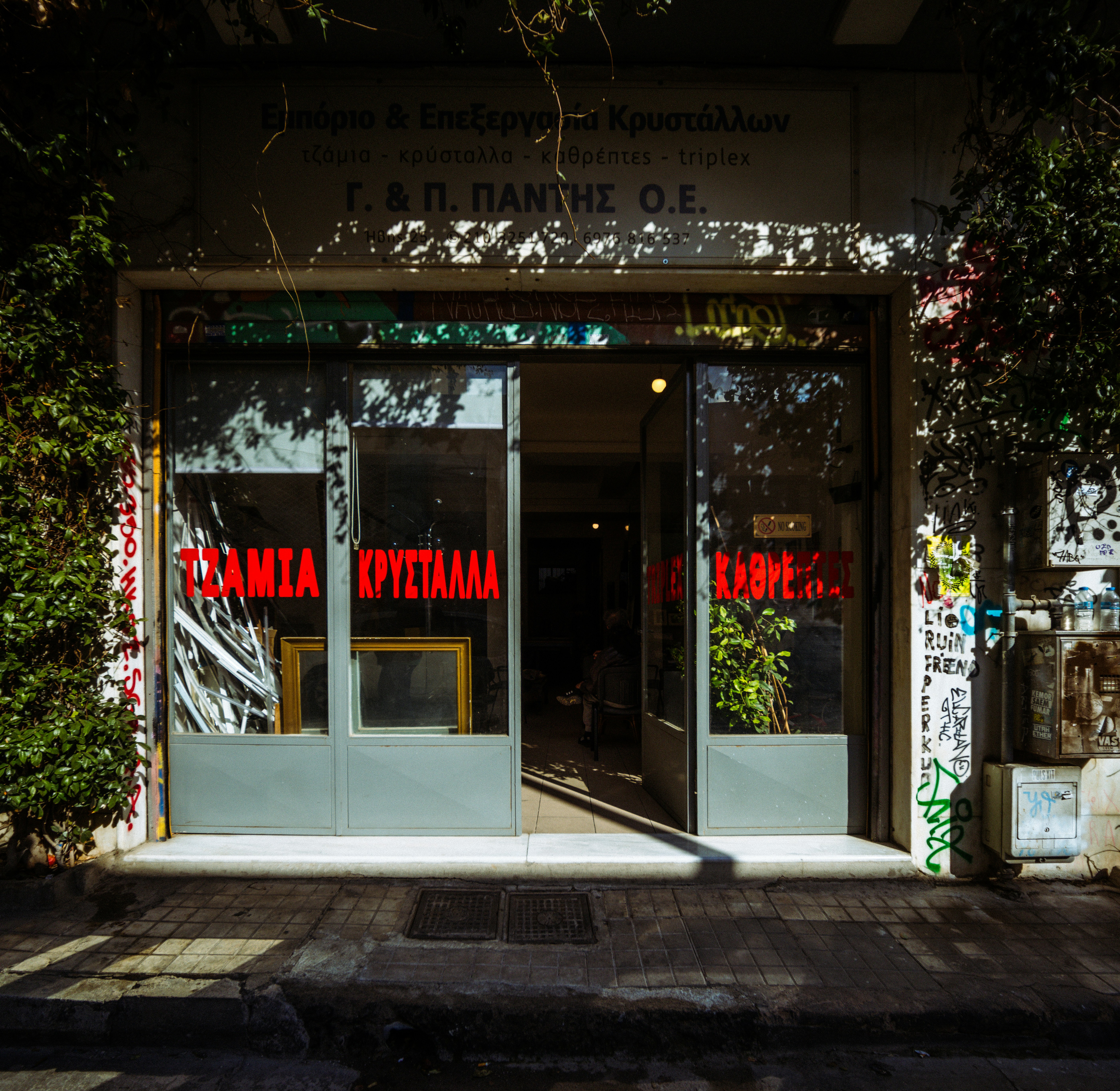 Red Neon Resolve: A Dim Corner of a Greek storefront