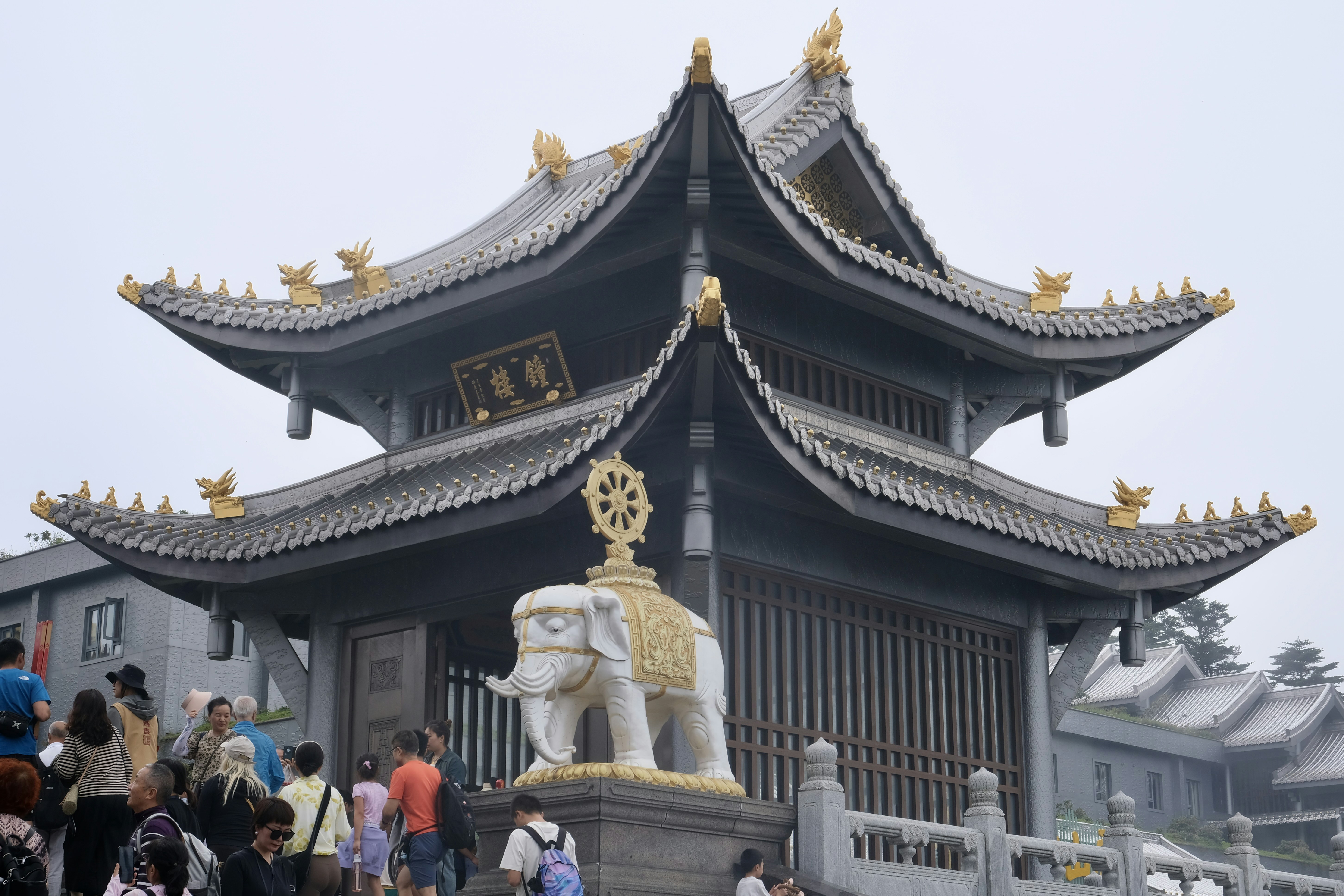 White Elephant Sentinel at a Multi-Tiered Temple Roofscape