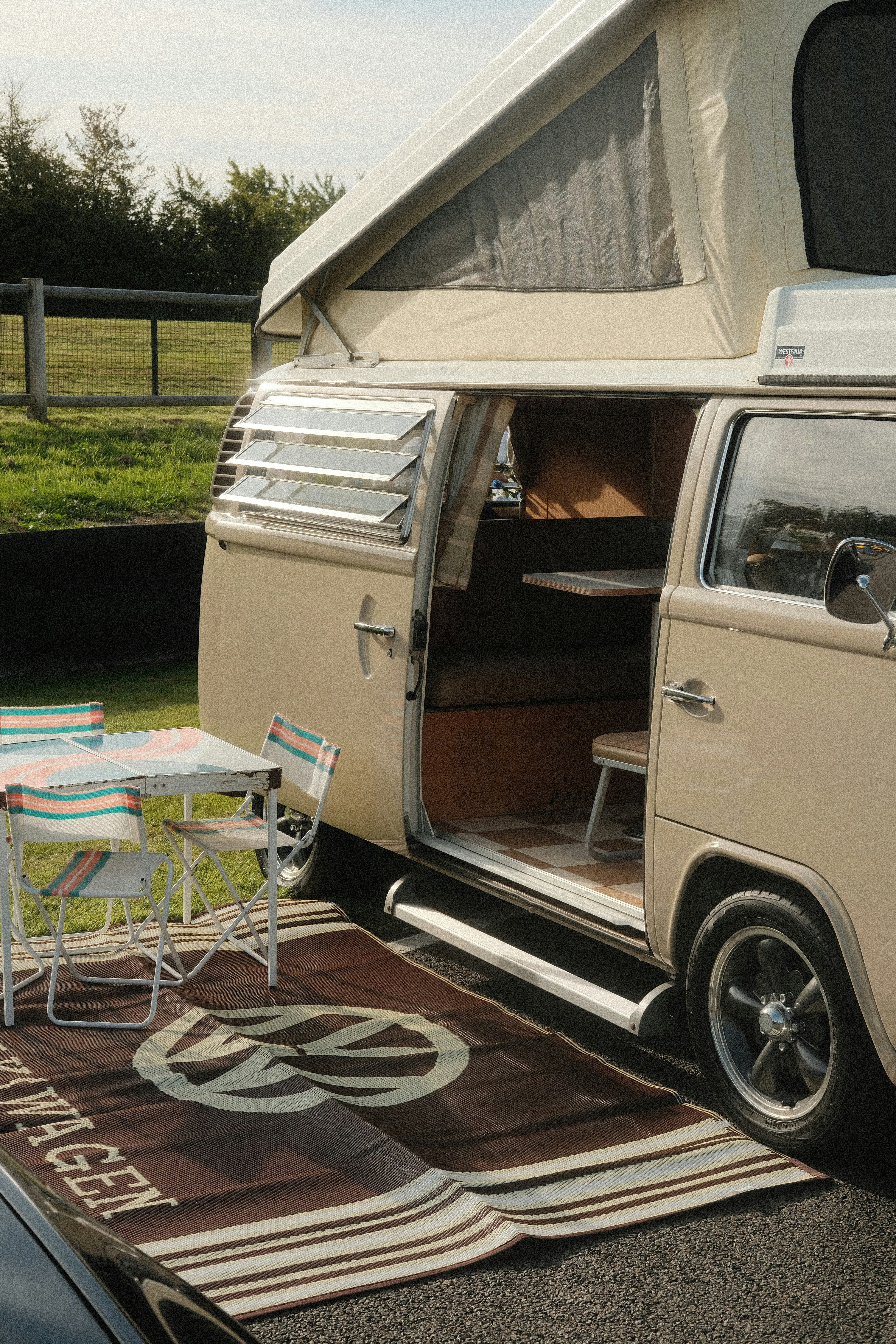 Sunlit Vintage VW Camper Opens to Cozy Outdoor Lounge with Striped Chairs