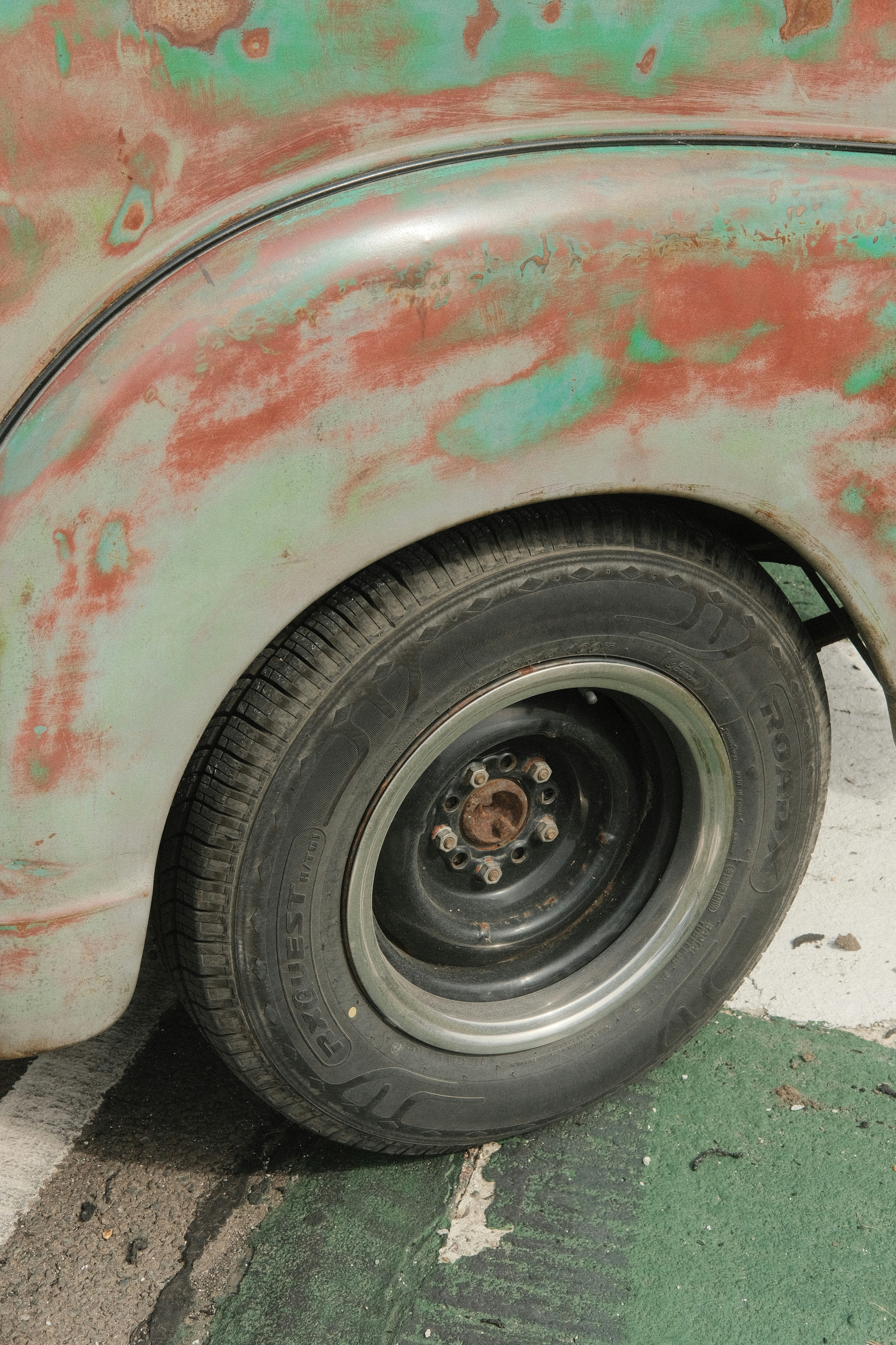 Patinaed Wheel in Green and Rust: A Quiet Vintage Car Detail
