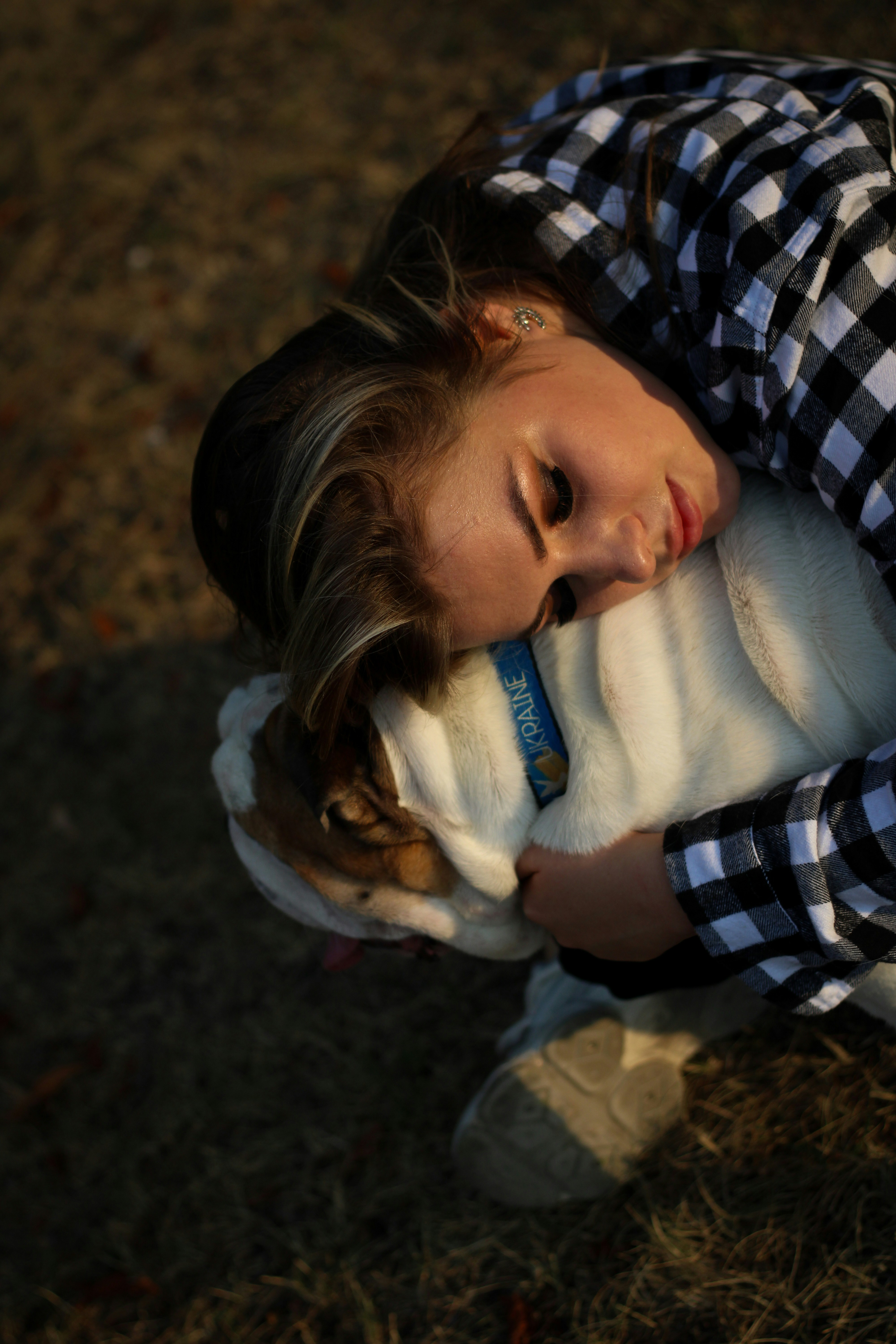 Dusk Embrace: A Girl and Her Dog Bathed in Warm Grass Light