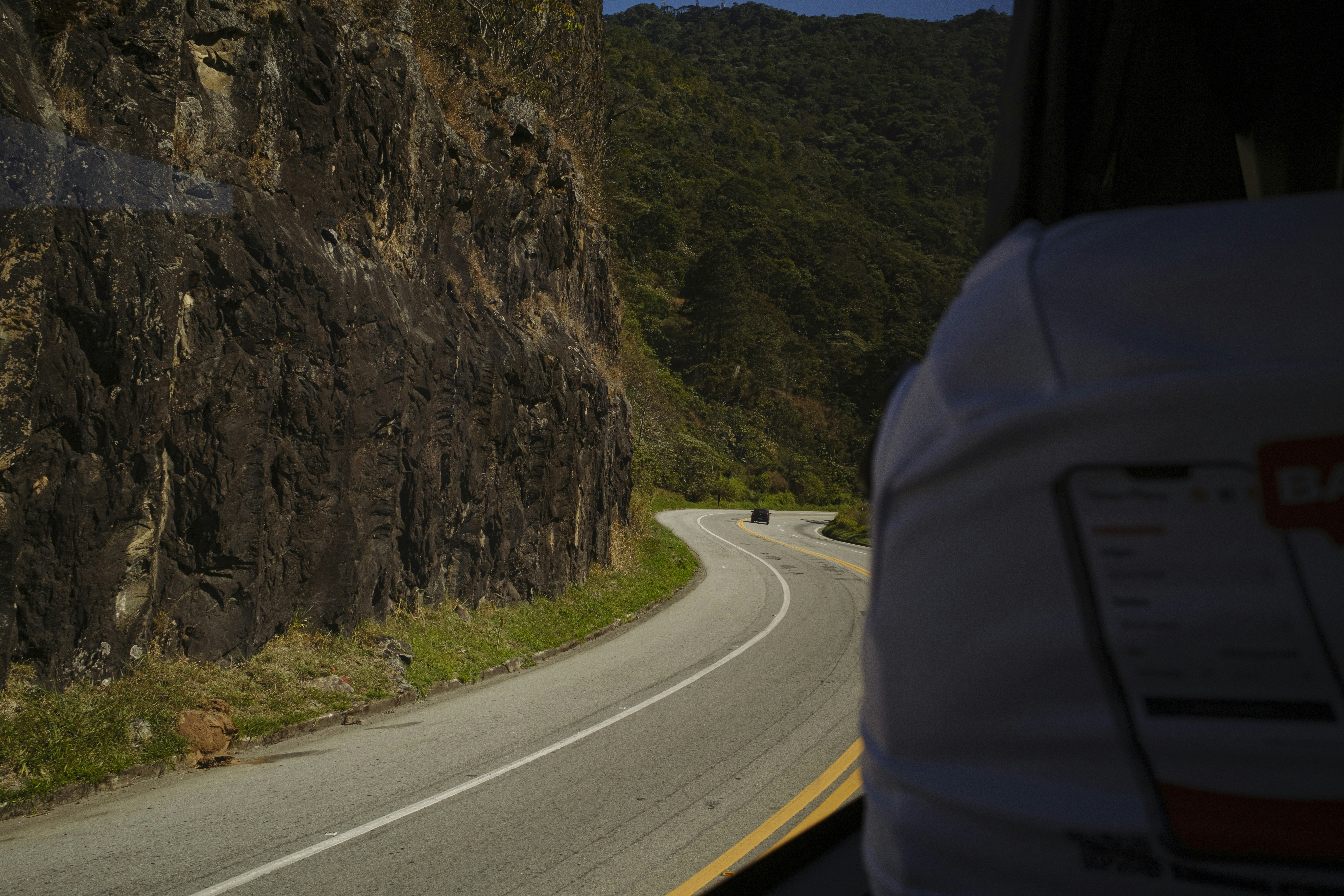 A car driving down a mountain road next to a cliff photo – Free Street ...