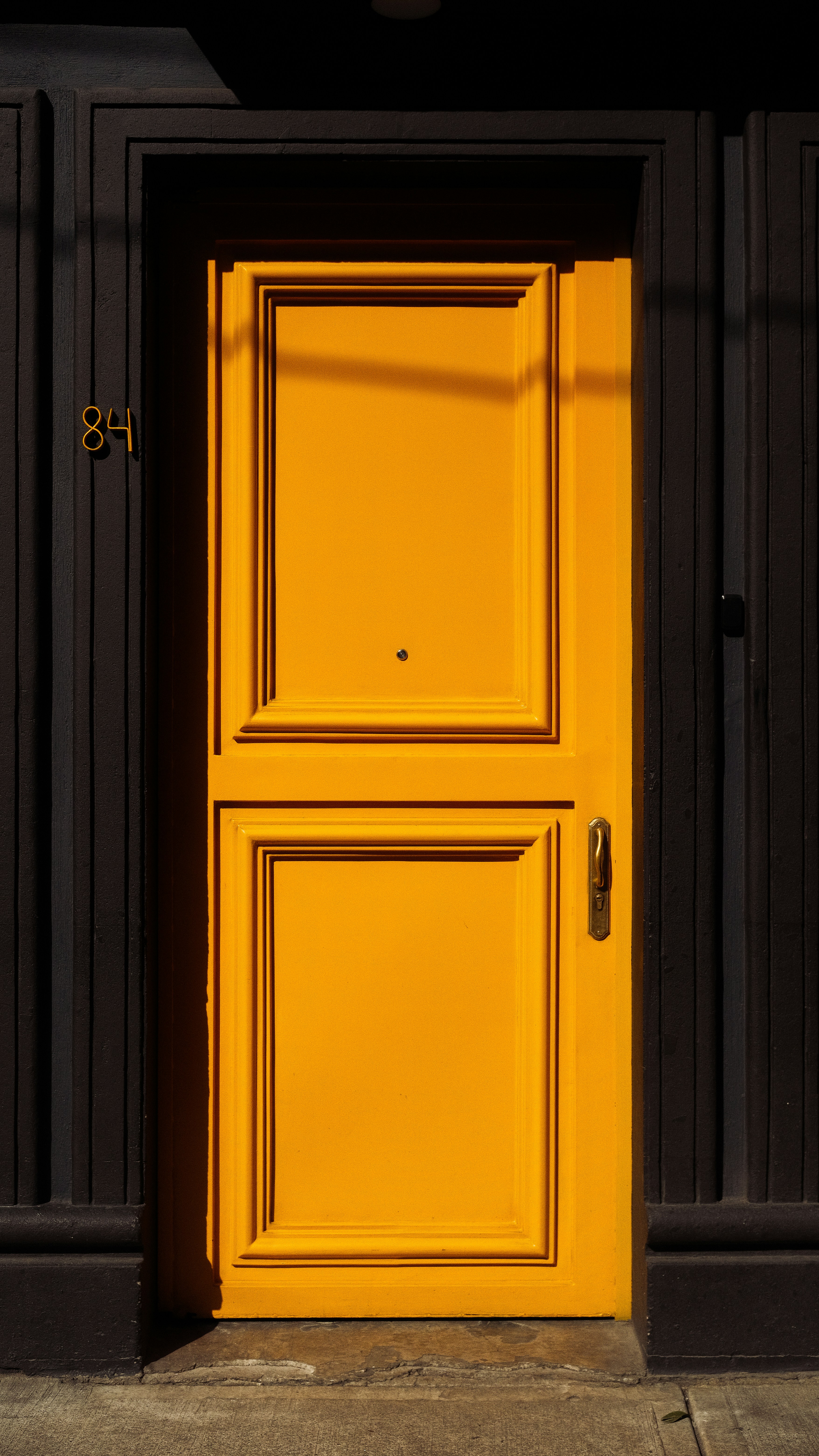 Una puerta amarilla brillante se encuentra frente a un edificio negro foto – Imagen de México ...