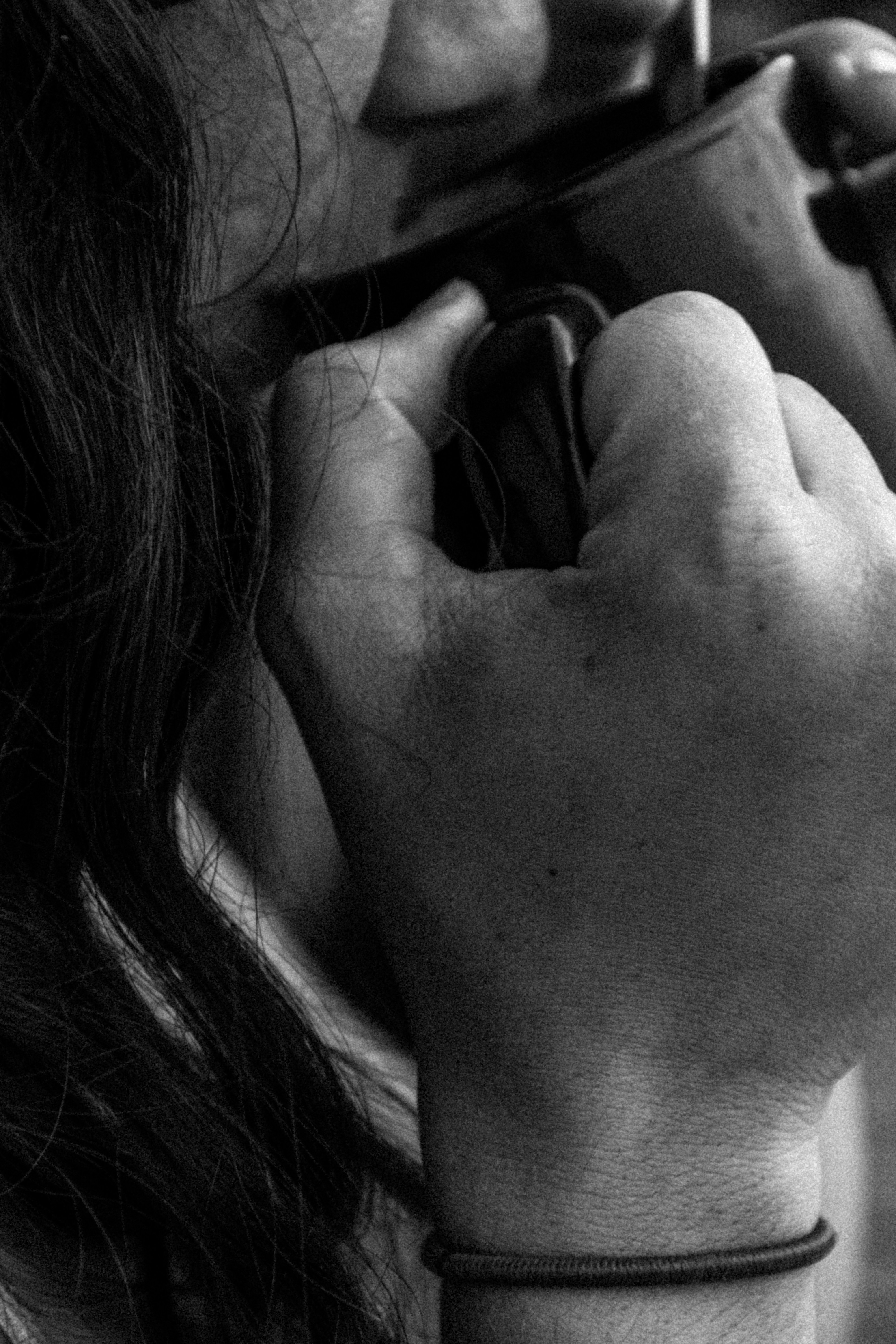 In the Grip: Close-Up of Fingers, Lens, and Craft in Monochrome