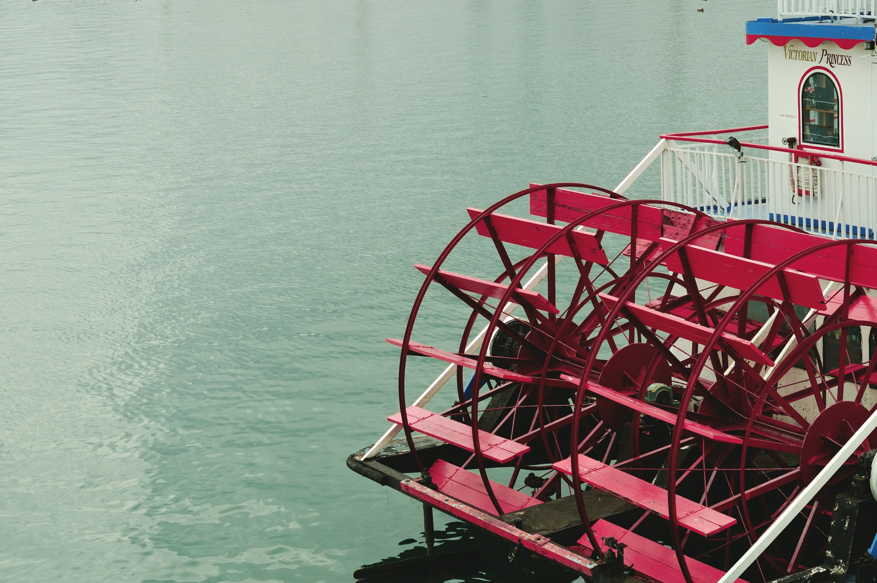 Crimson Waterwheel Adrift on Teal Waters