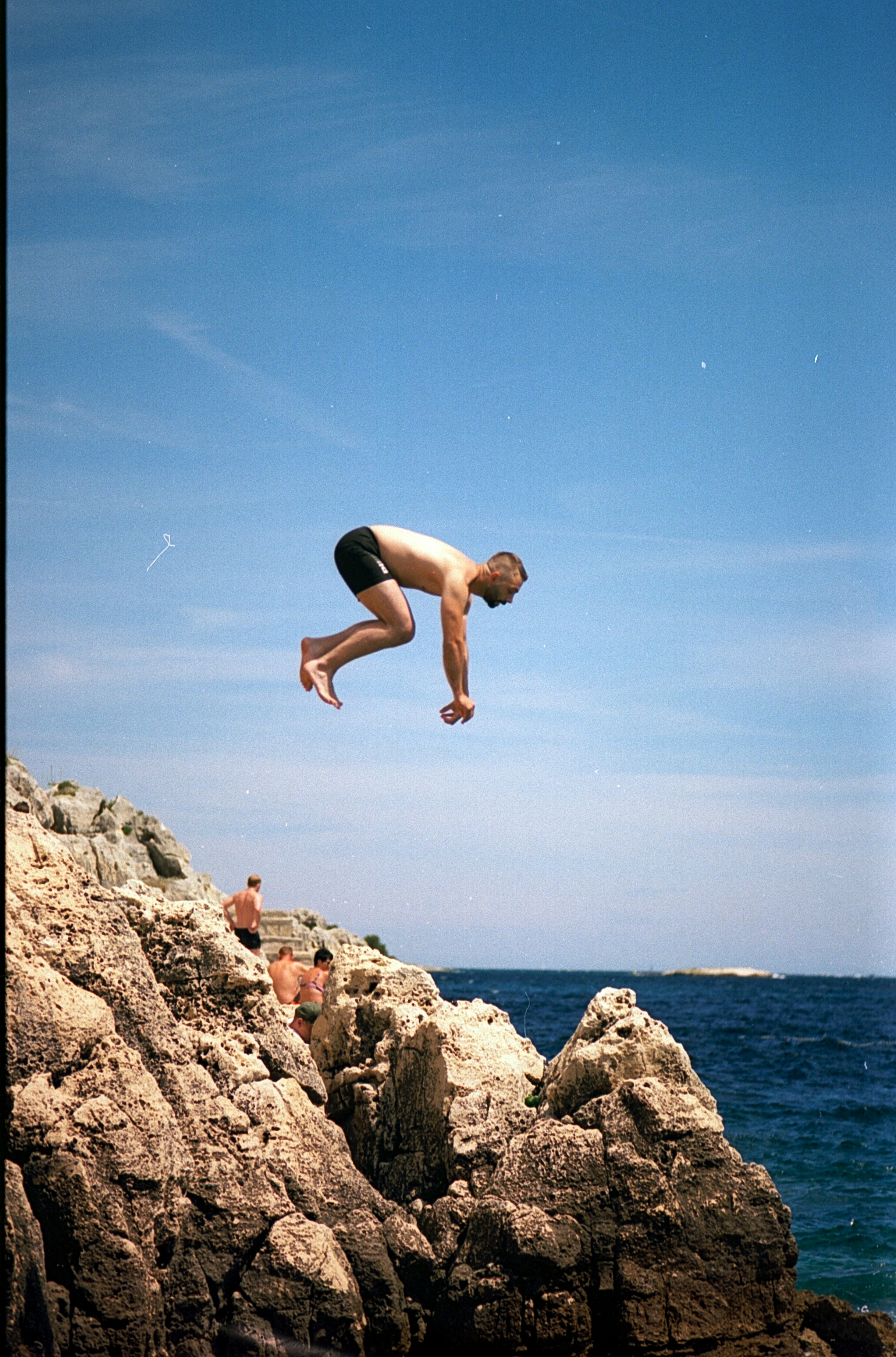Leap from the Ledge: A Sunlit Cliff Dive into the Atlantic