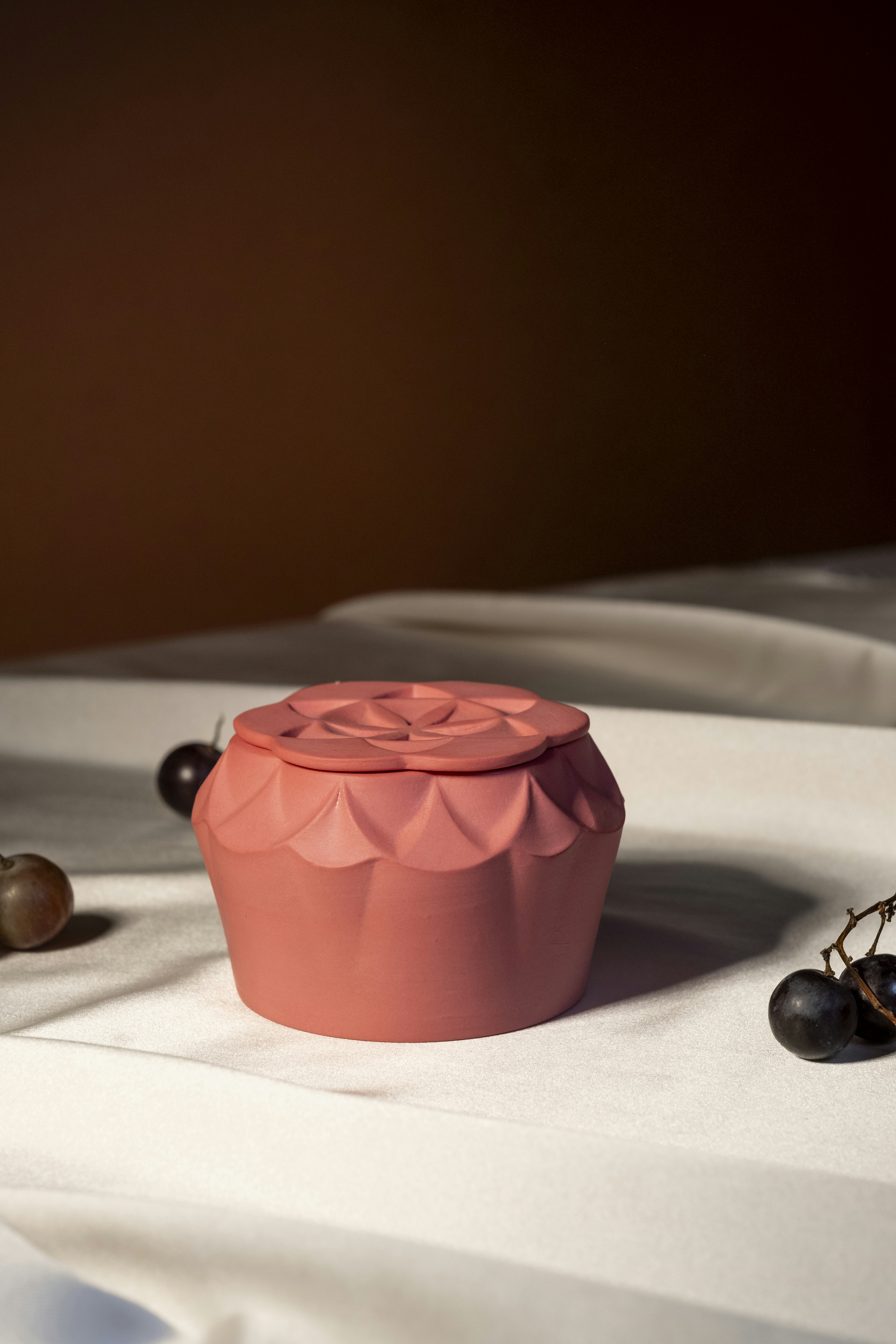 Petal-Patterned Terracotta Jar Anchoring a Quiet Studio Still-Life