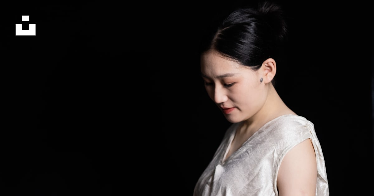 흰 드레스를 입은 여자가 어두운 방에 서 있다 사진 Unsplash의 무료 아시아 여성 이미지