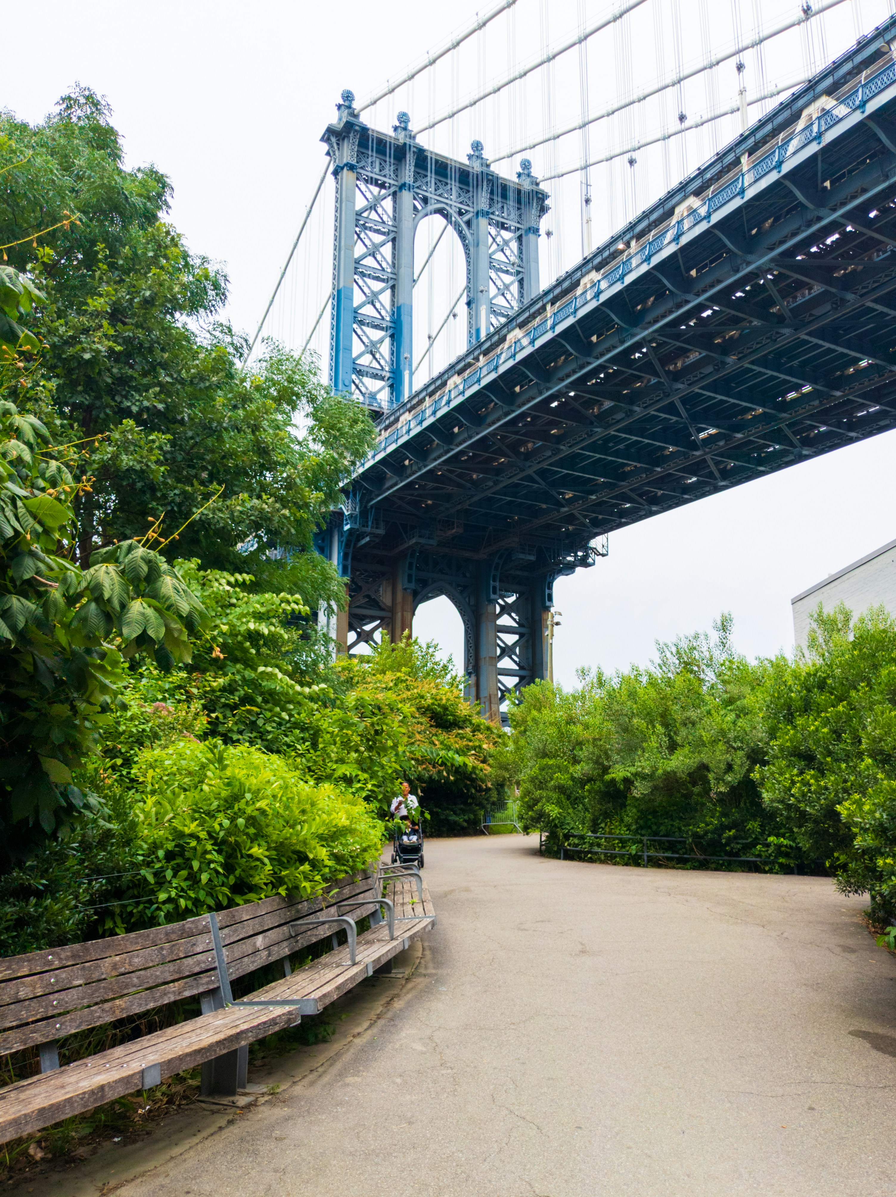 Under the Blue Span: A Quiet Park Walk Framed by Steel and Green