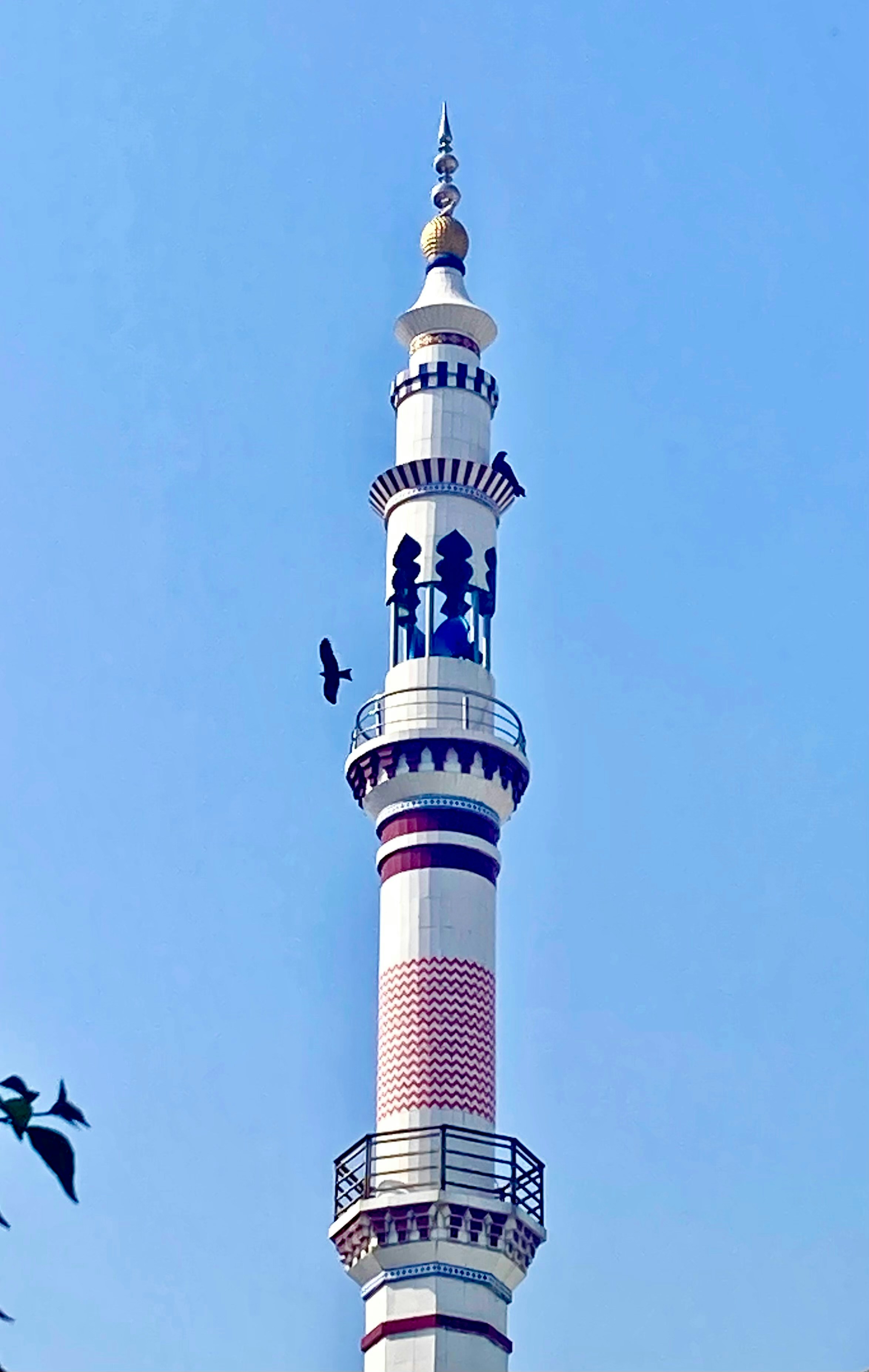 Azure Spire in Clear Light: A White-and-Blue Tower Piercing the Sky