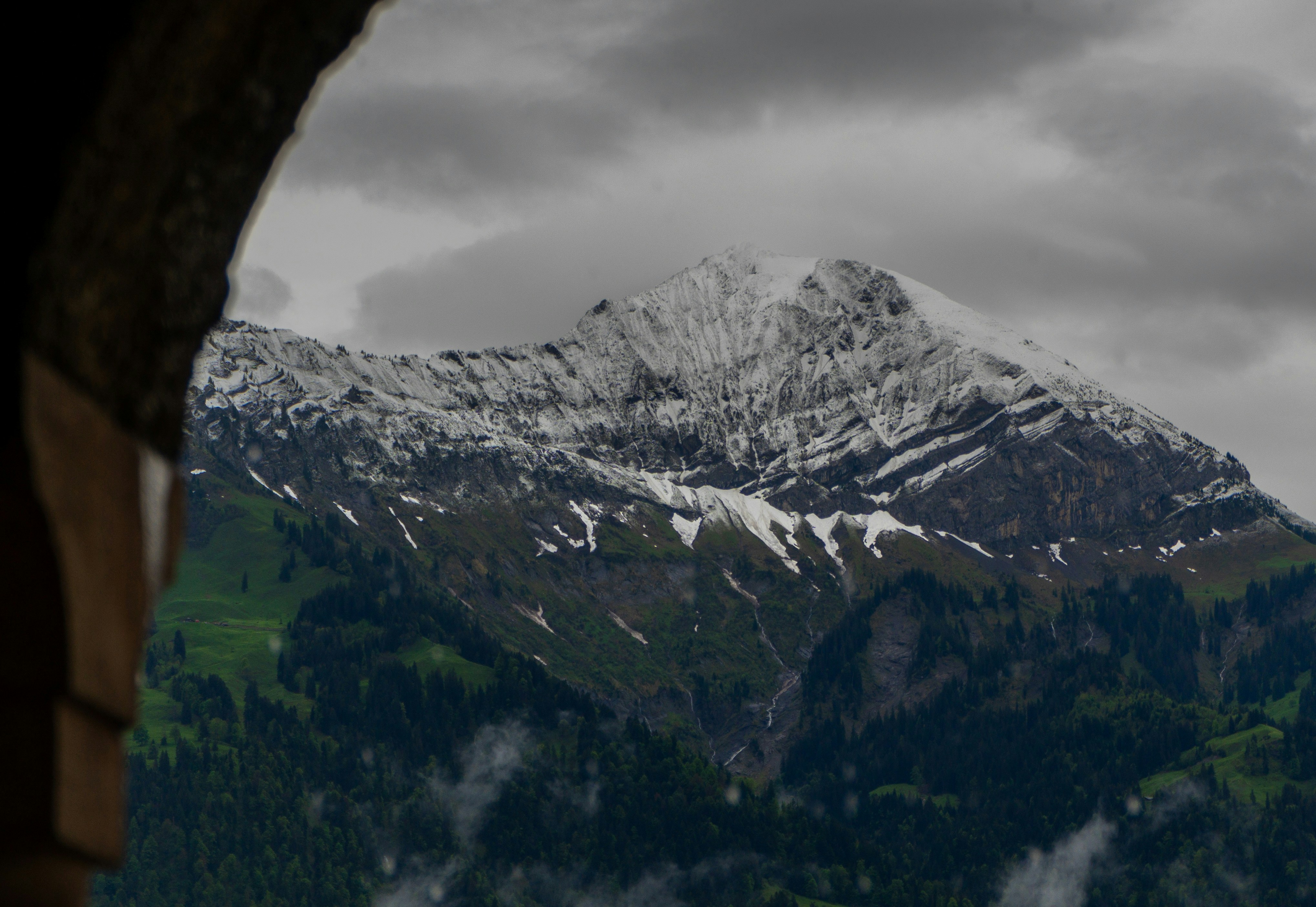 Gate to the Alps: Snow-Capped Summit Through a Weathered Arch