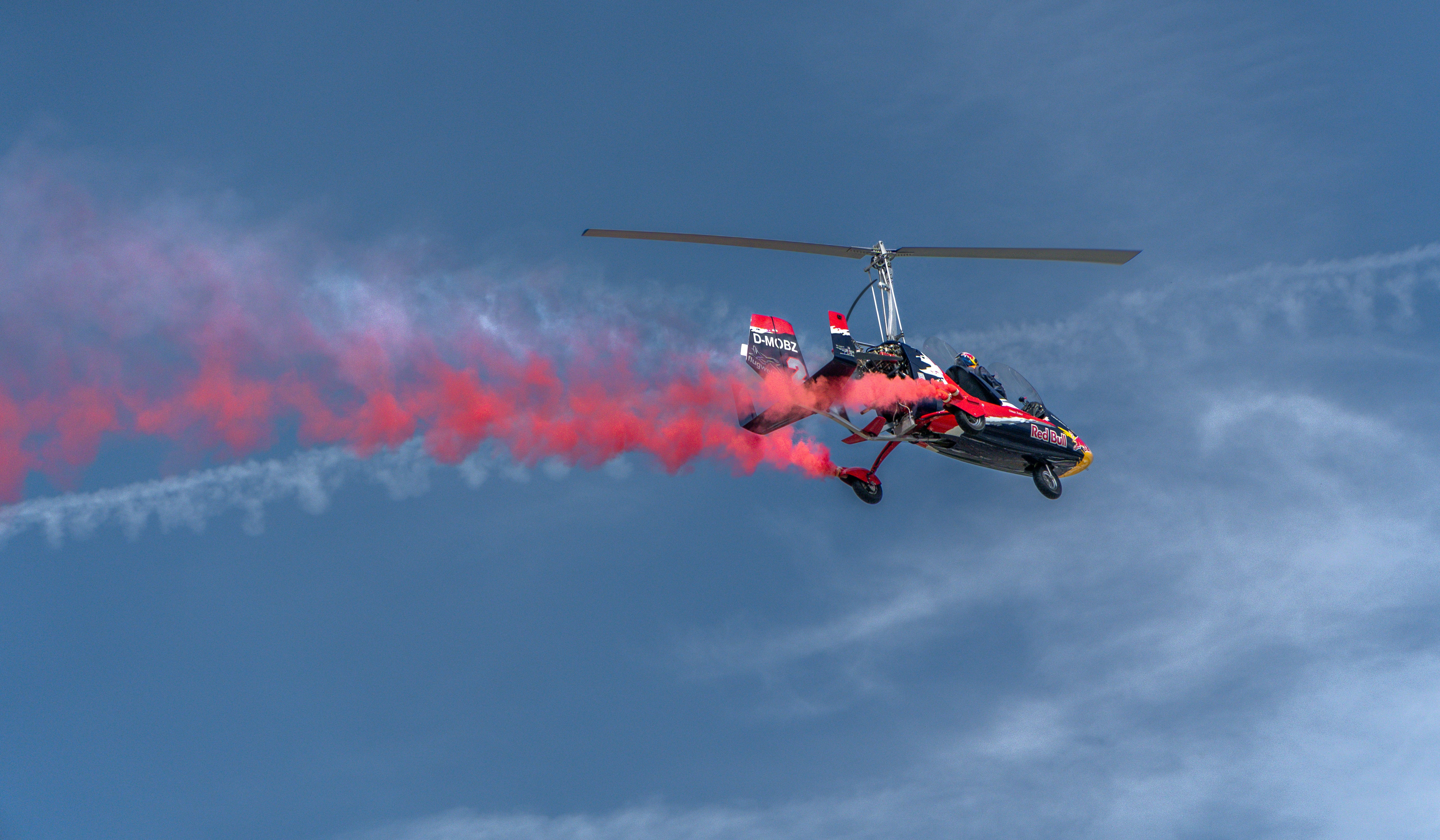 Crimson Trail Rider: Aerial smoke and rotor dance from a high-speed helicopter
