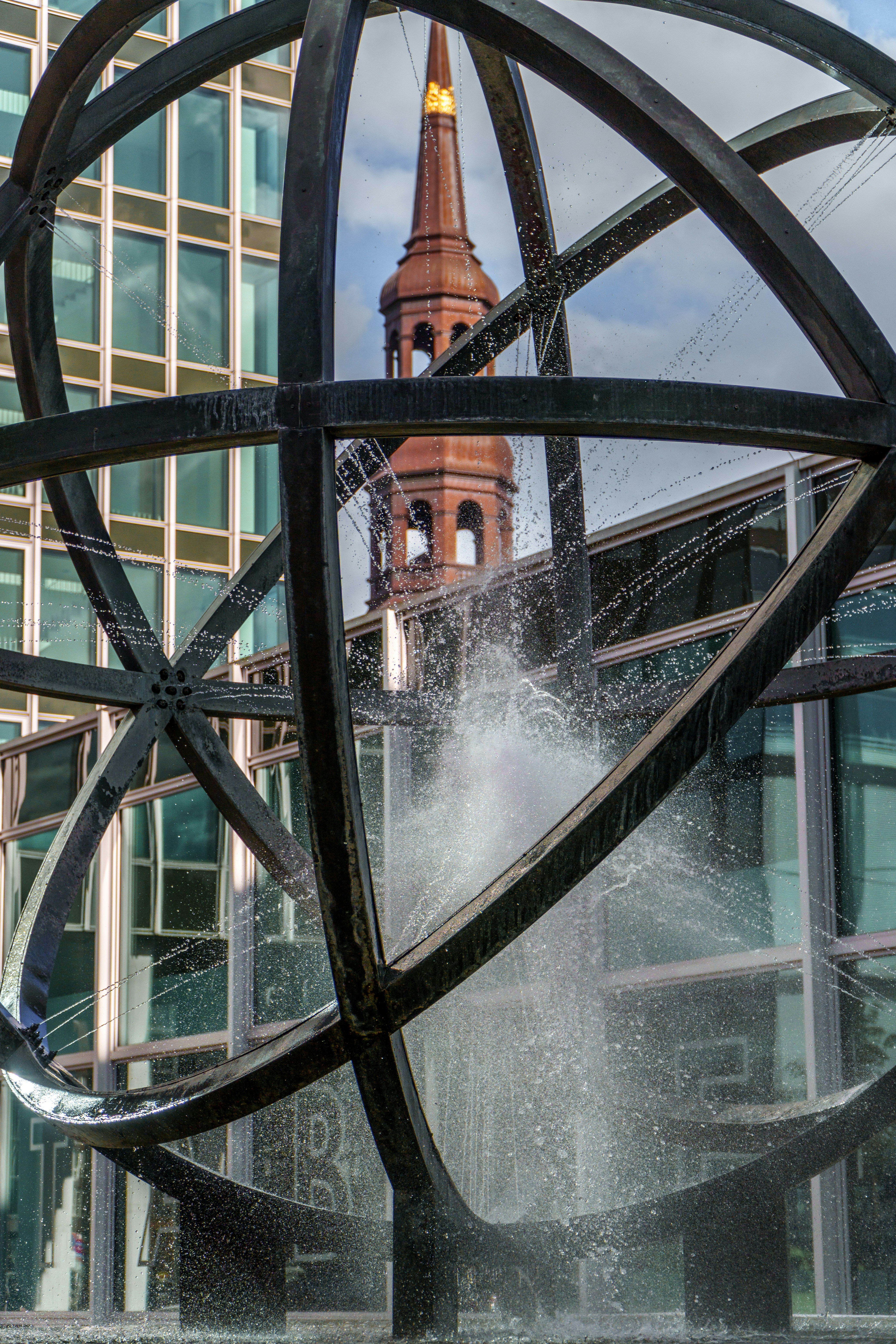 Una fuente de agua frente a un edificio alto foto – Imagen de Globus ...