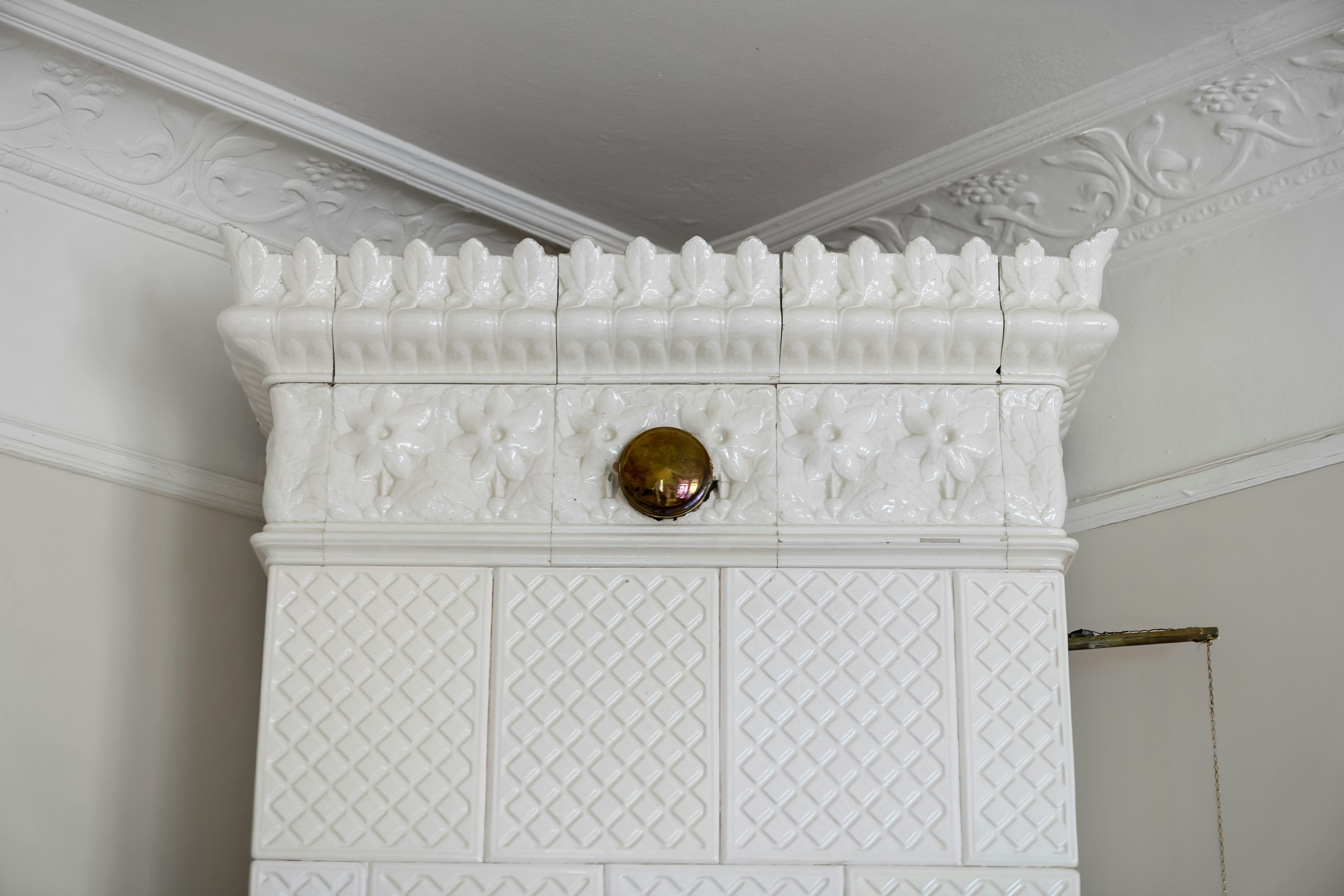 Brass Orb on a Snow-White Cabinet: Quiet Ornament in a Monochrome Room