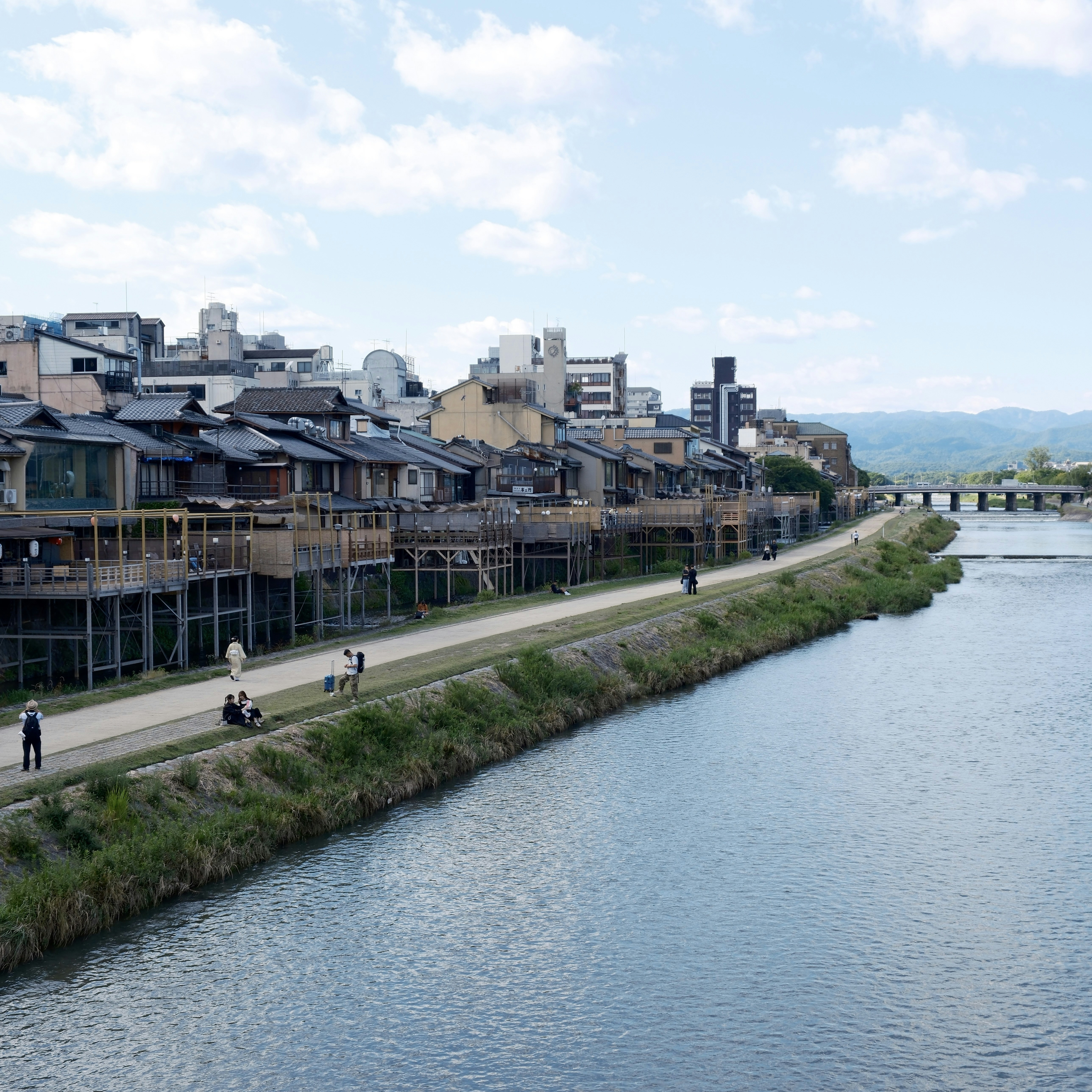 Riverside Timberline: Wooden houses along a sunlit riverbank