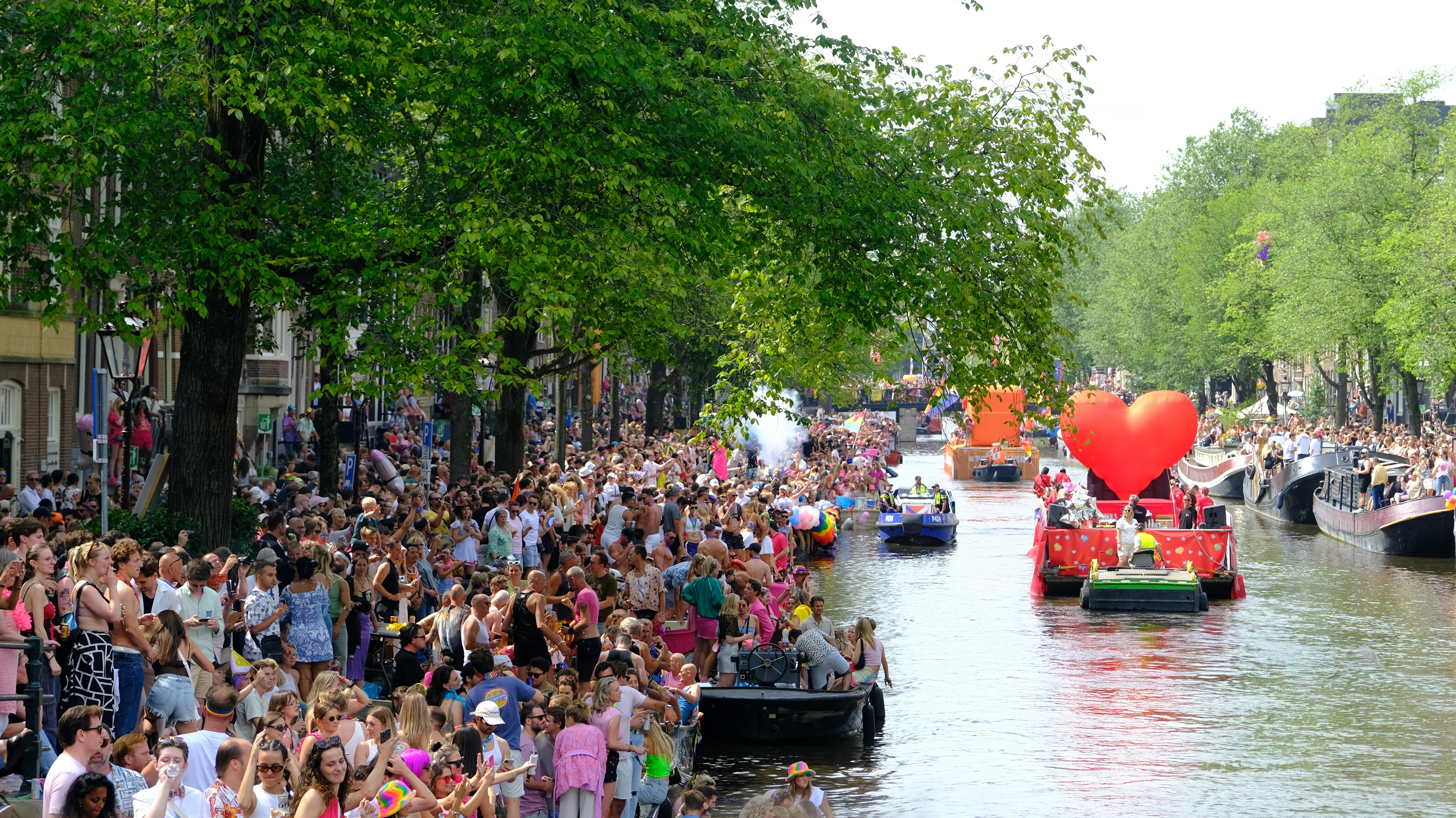 A large group of people watching a boat float down a river photo – Free ...