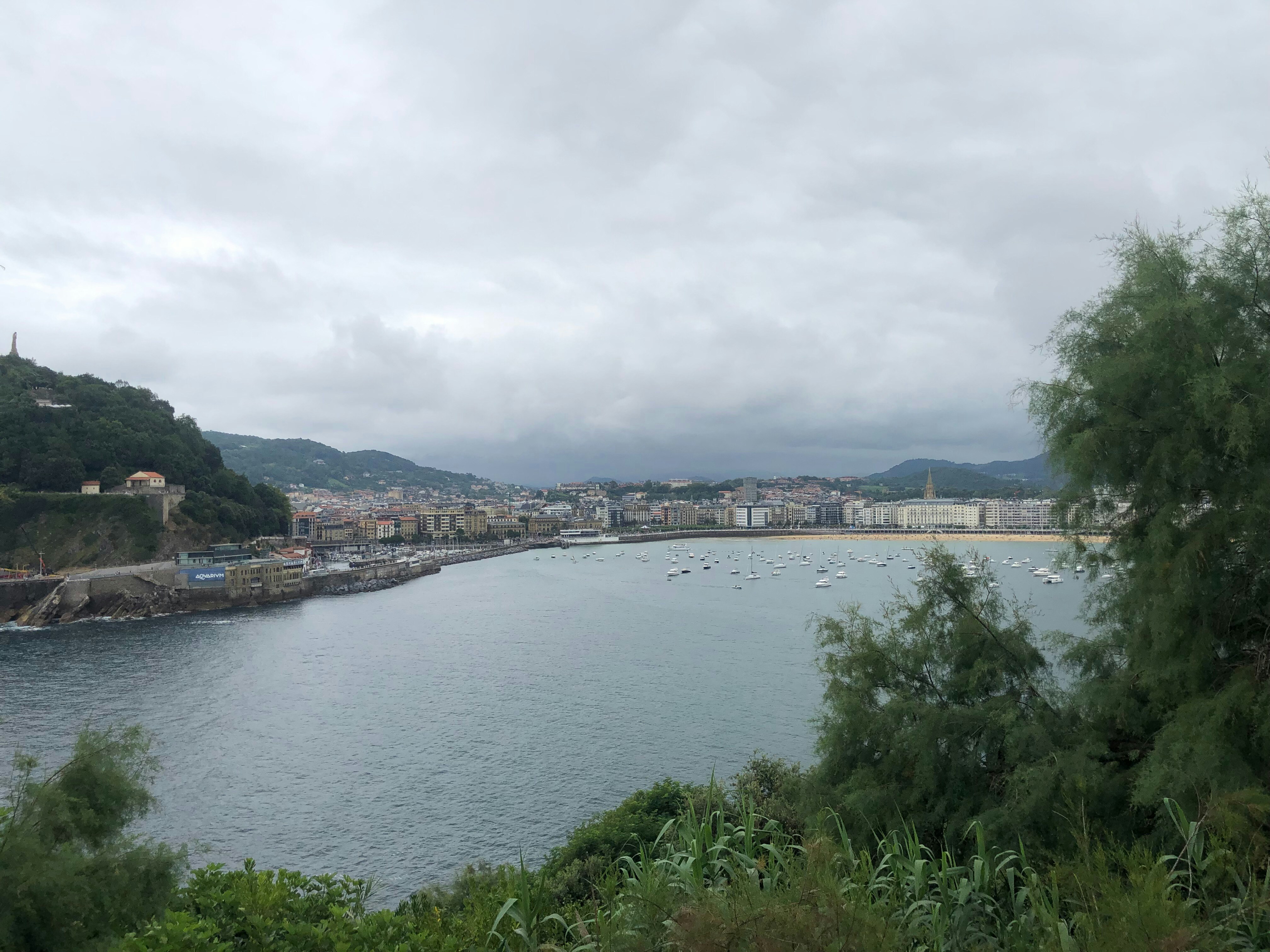 Harbor Shadows: A Curved Waterfront Under Cloudy Skies