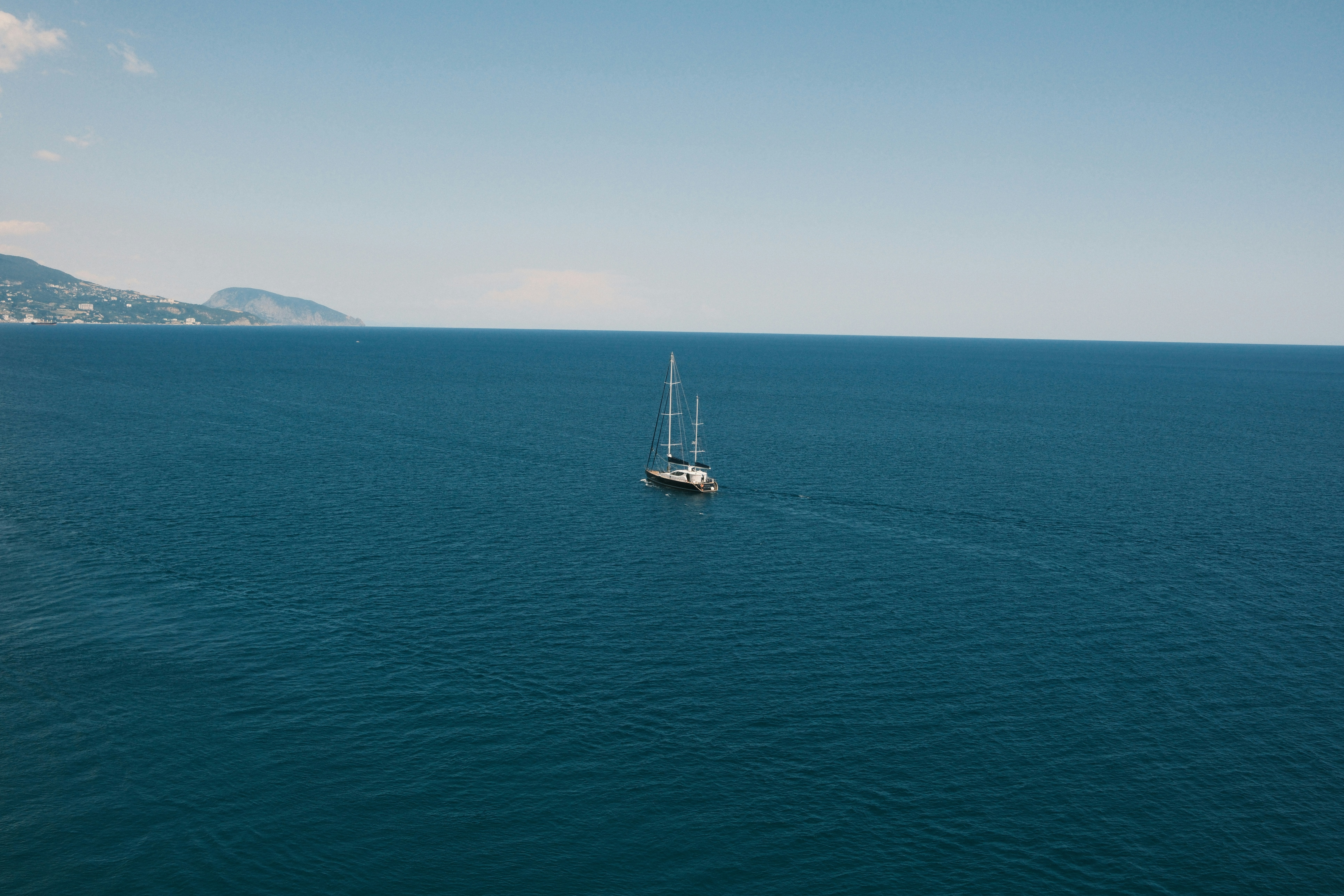 A sailboat in the middle of a large body of water photo – Free Sea ...
