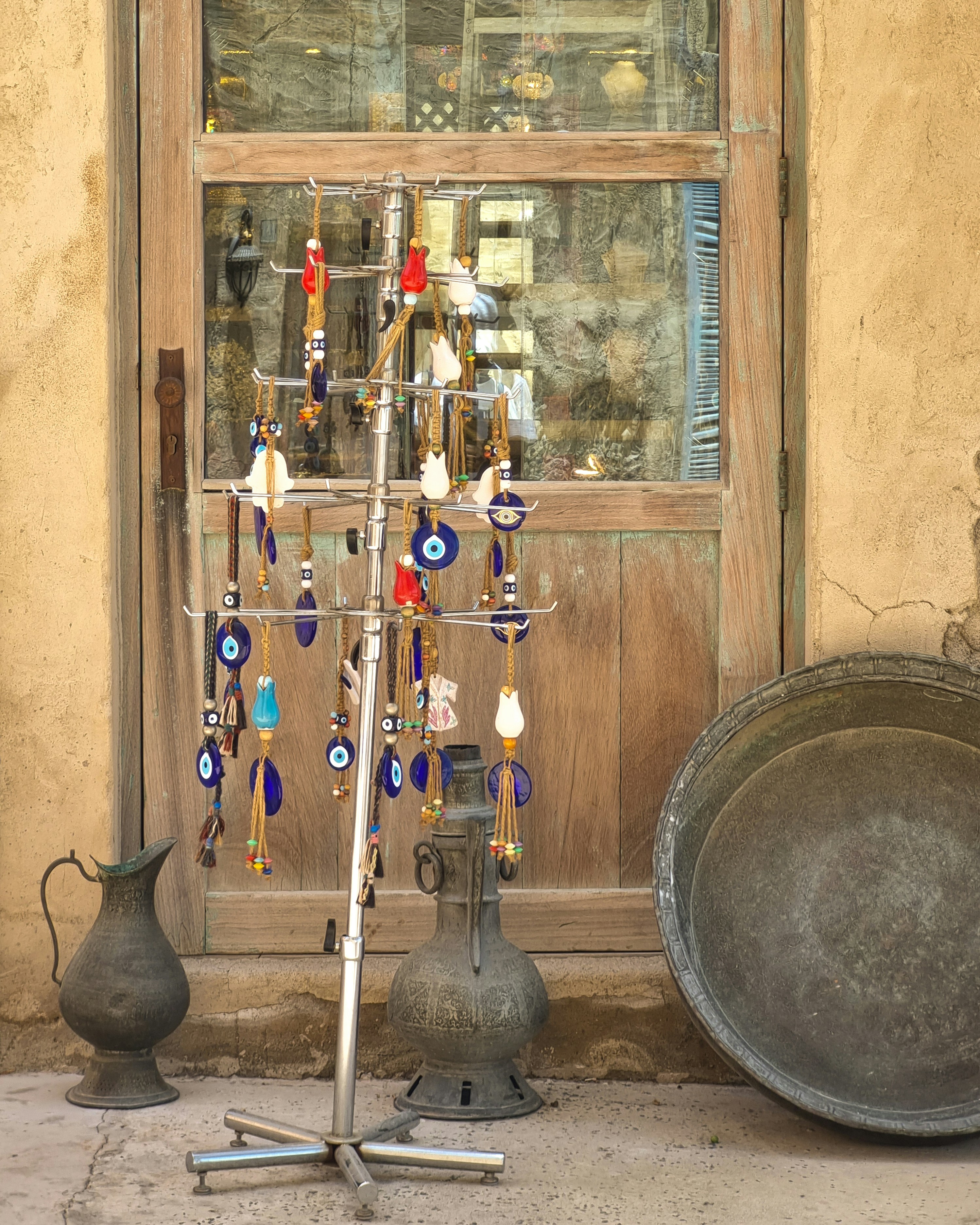 Beaded Wind: An Artisan’s Display in a Sunlit Doorway