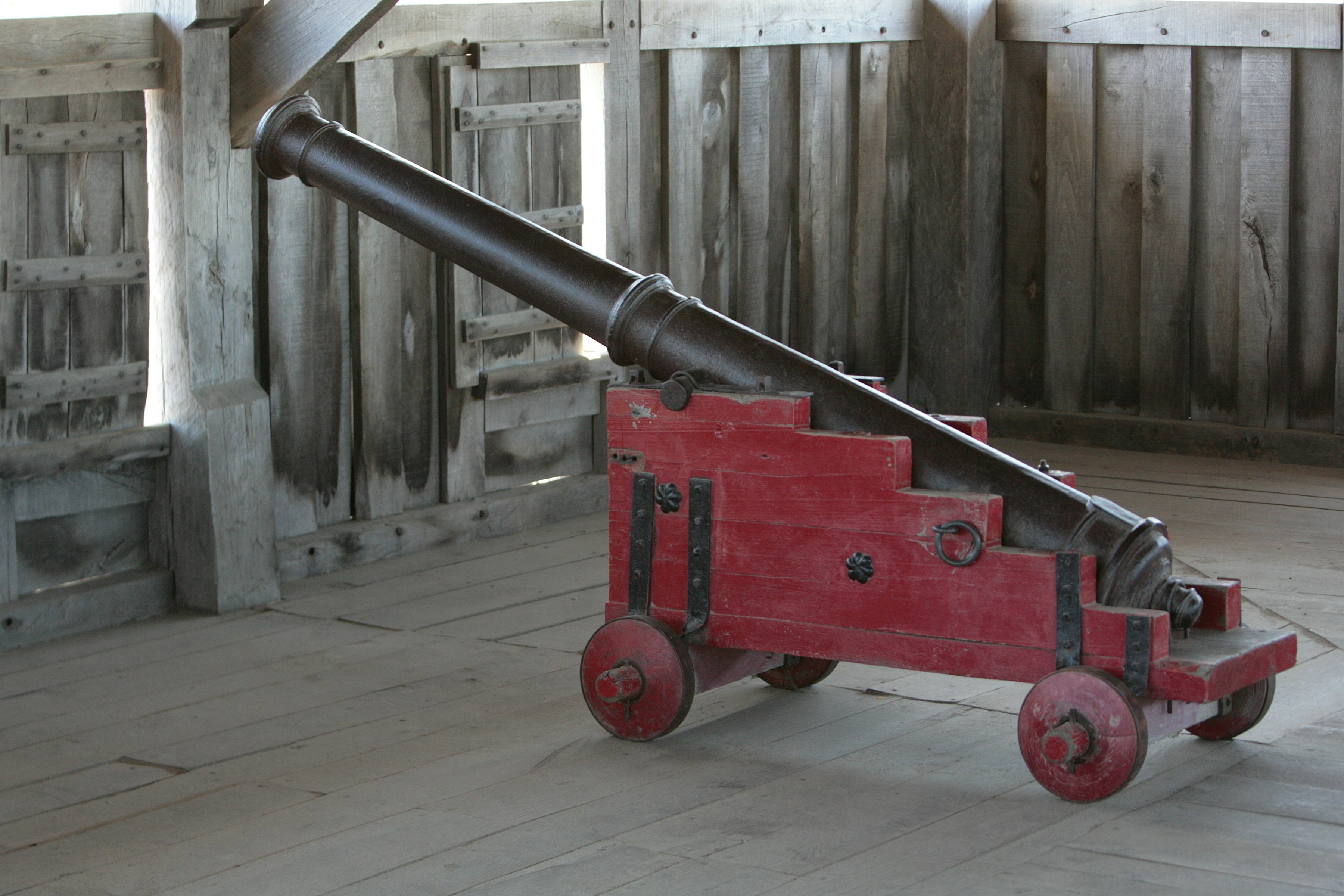 A red cannon sitting on top of a wooden floor photo – Free Cannon Image on Unsplash