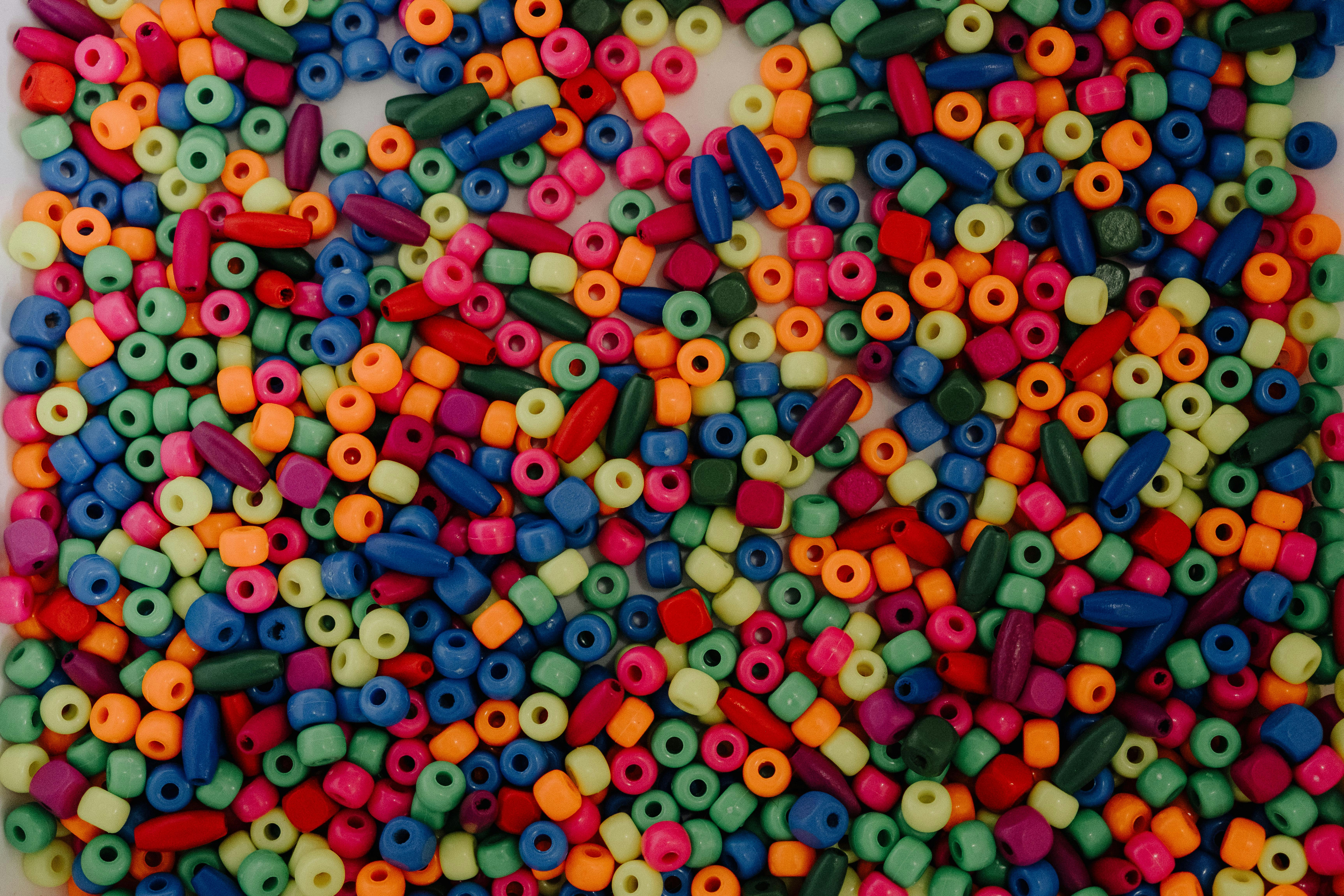 A pile of colorful beads sitting on top of a table photo – Free School ...