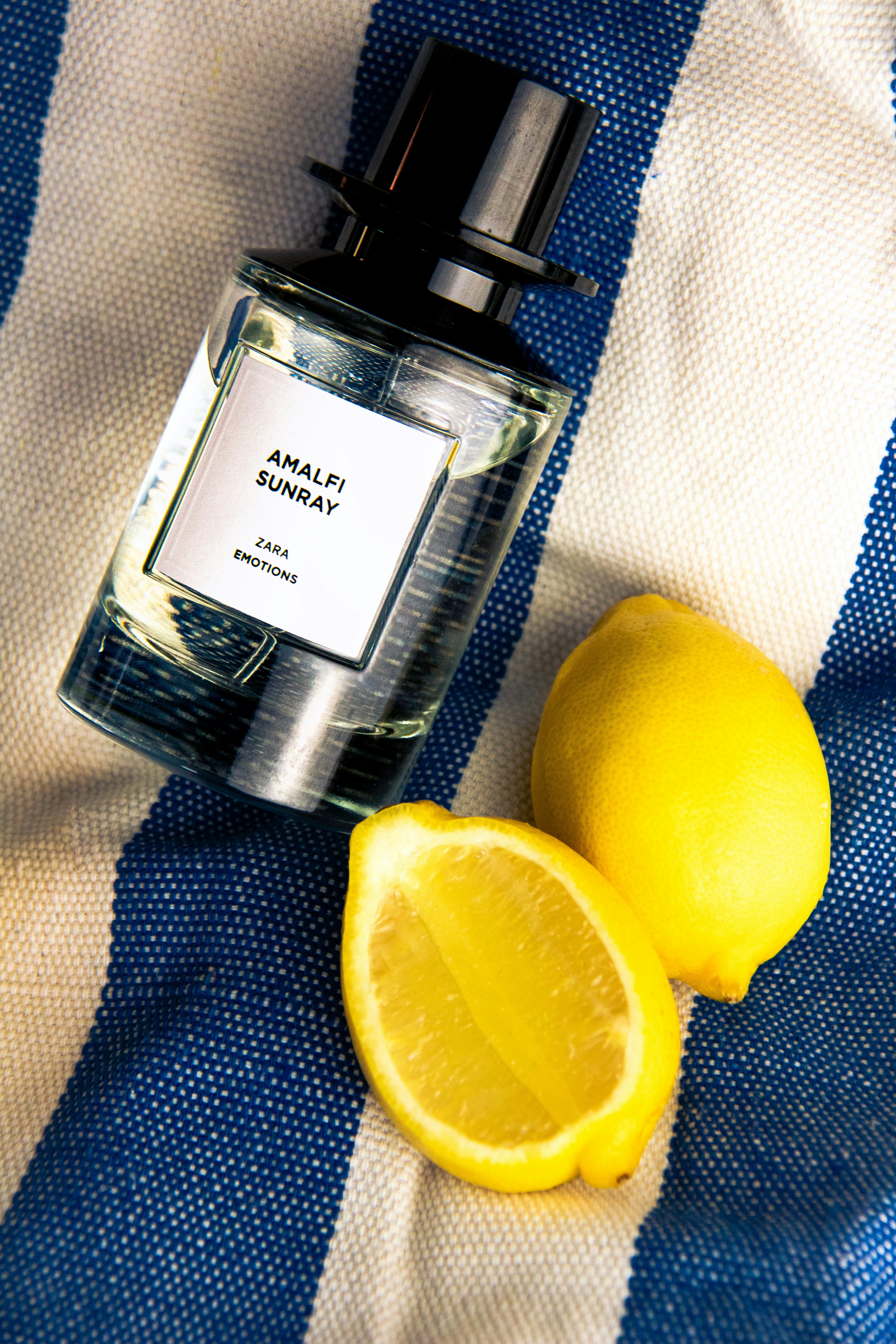 Amalfi Sunray: A Perfume Bottle Resting by Bright Lemons