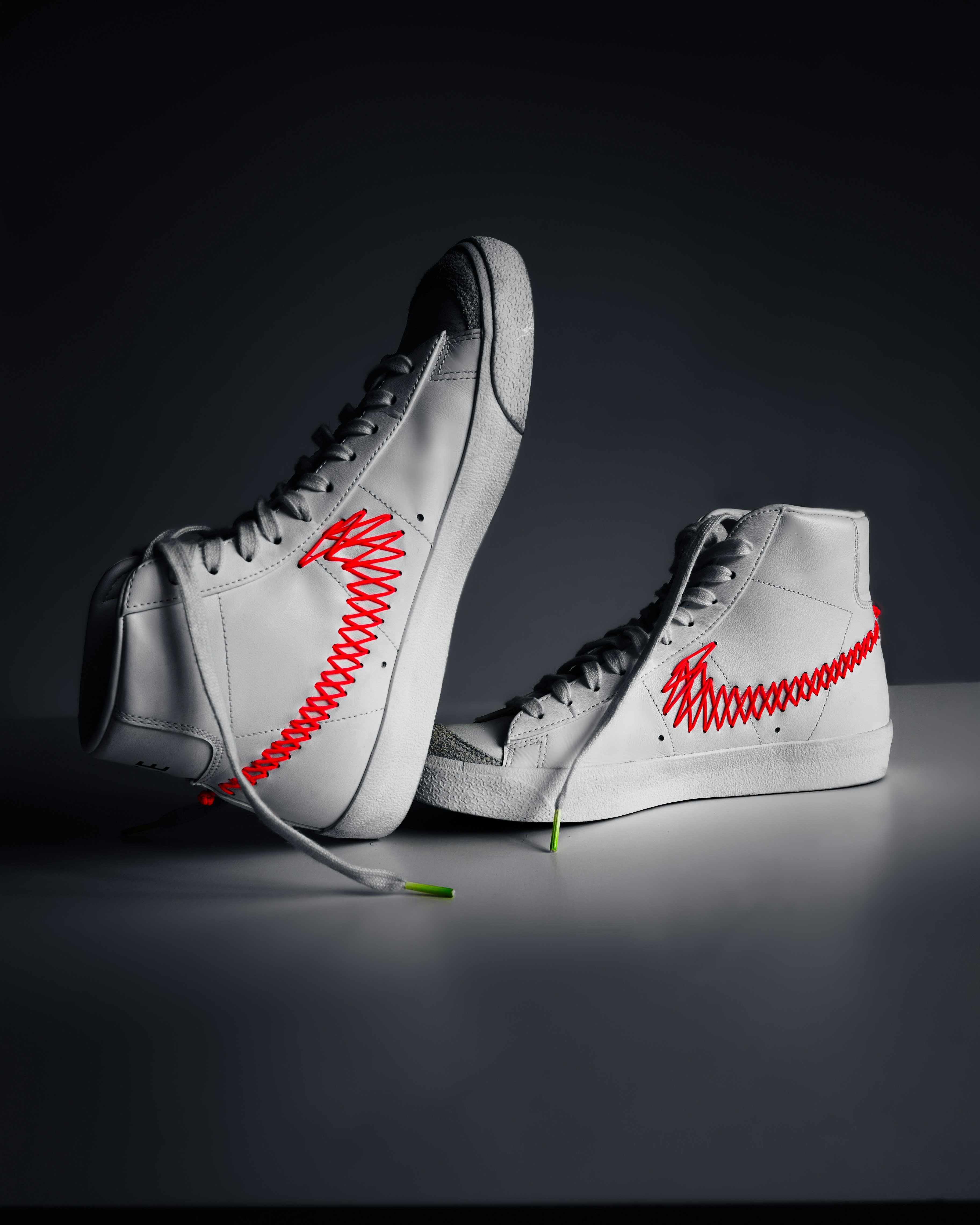 A pair of white sneakers with red stitches on them photo – Free Los ...