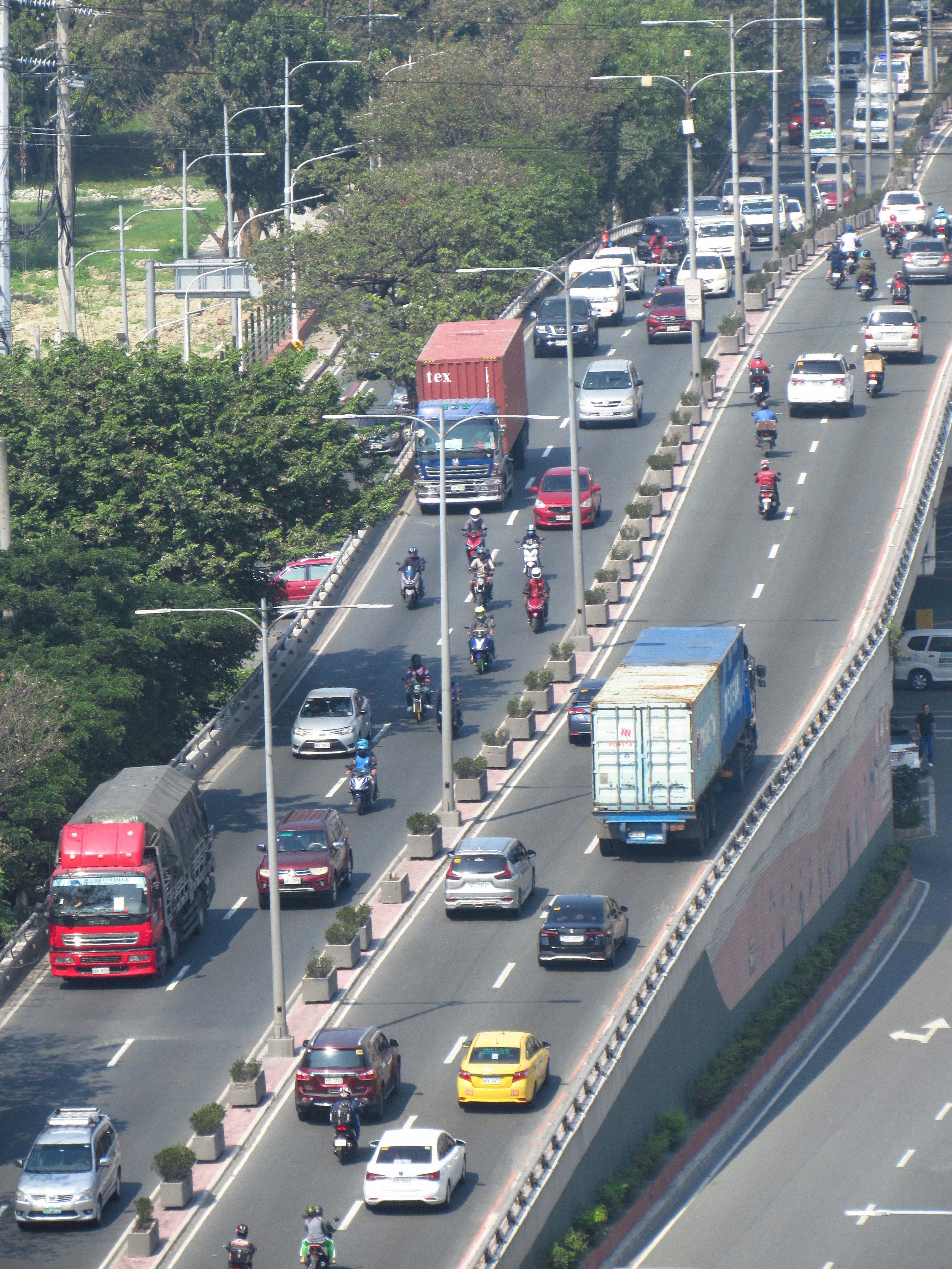 A highway filled with lots of traffic next to trees photo – Free Truck ...