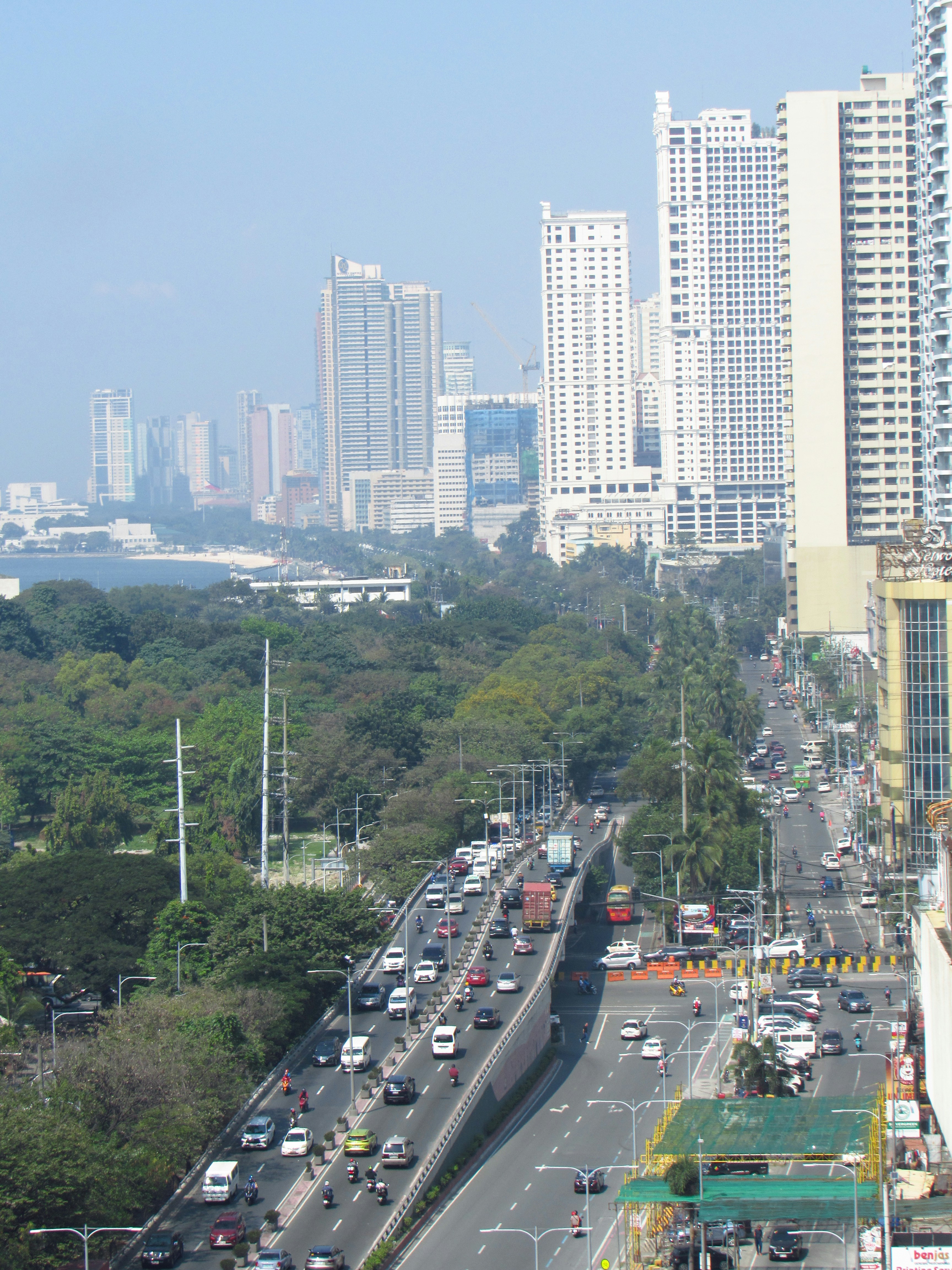 A vibrant cityscape showcasing bustling traffic and towering skyscrapers against a clear blue sky.