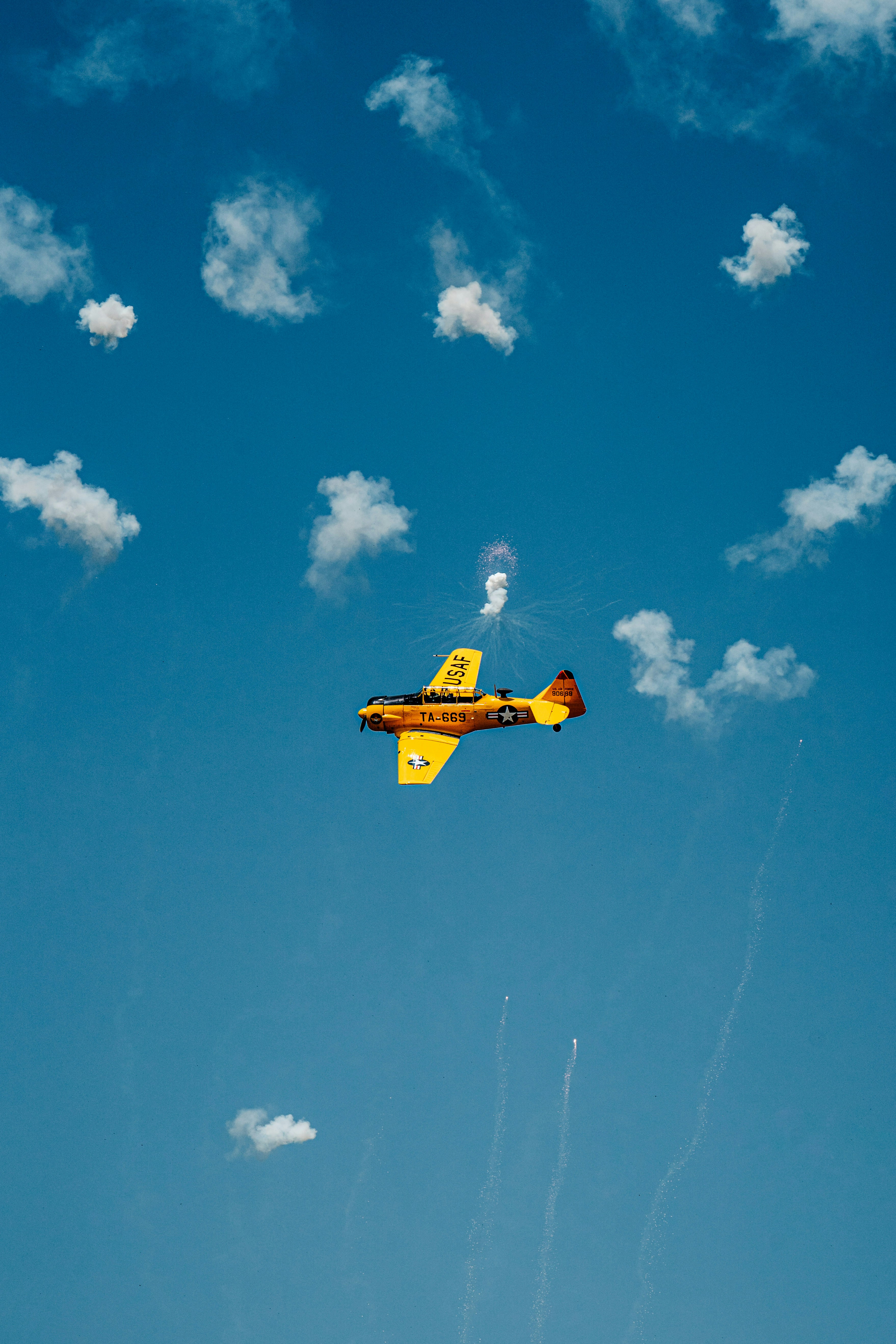 A yellow airplane flying through a blue sky photo – Free Animal Image ...