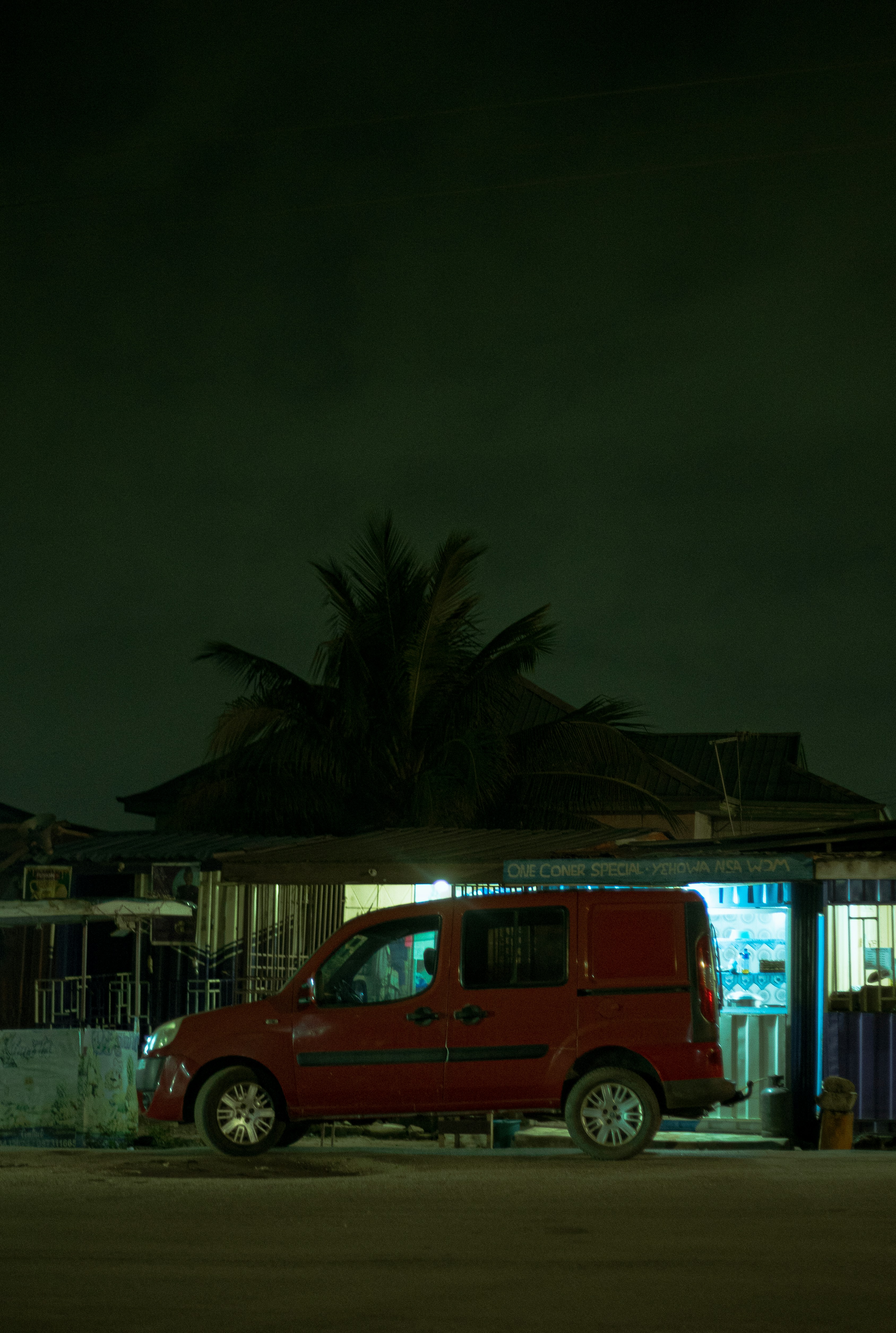 Neon Glow by the Shore: Red Van at a Night Market Stand