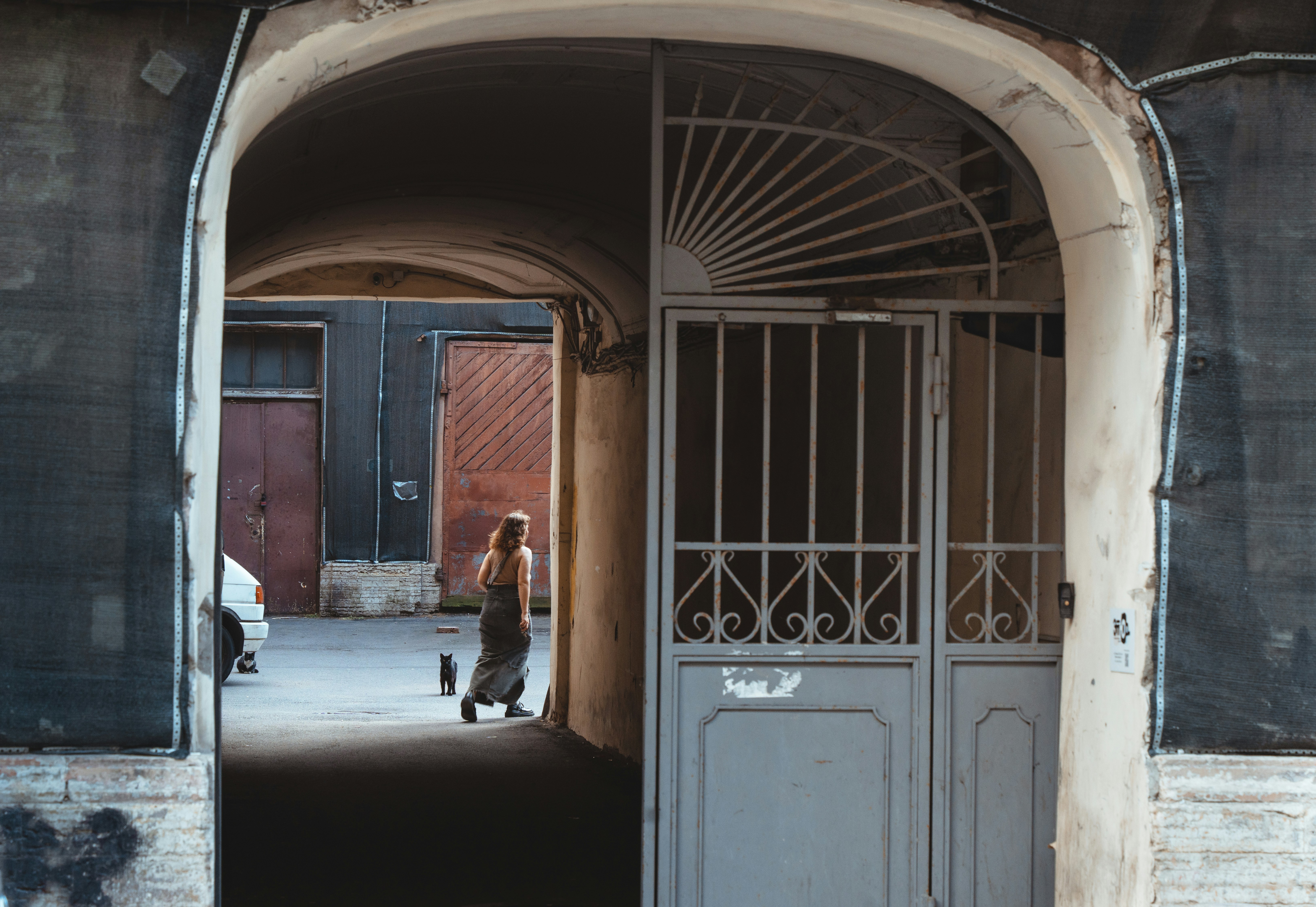 A person is walking out of a gated entrance photo – Free Door Image on ...